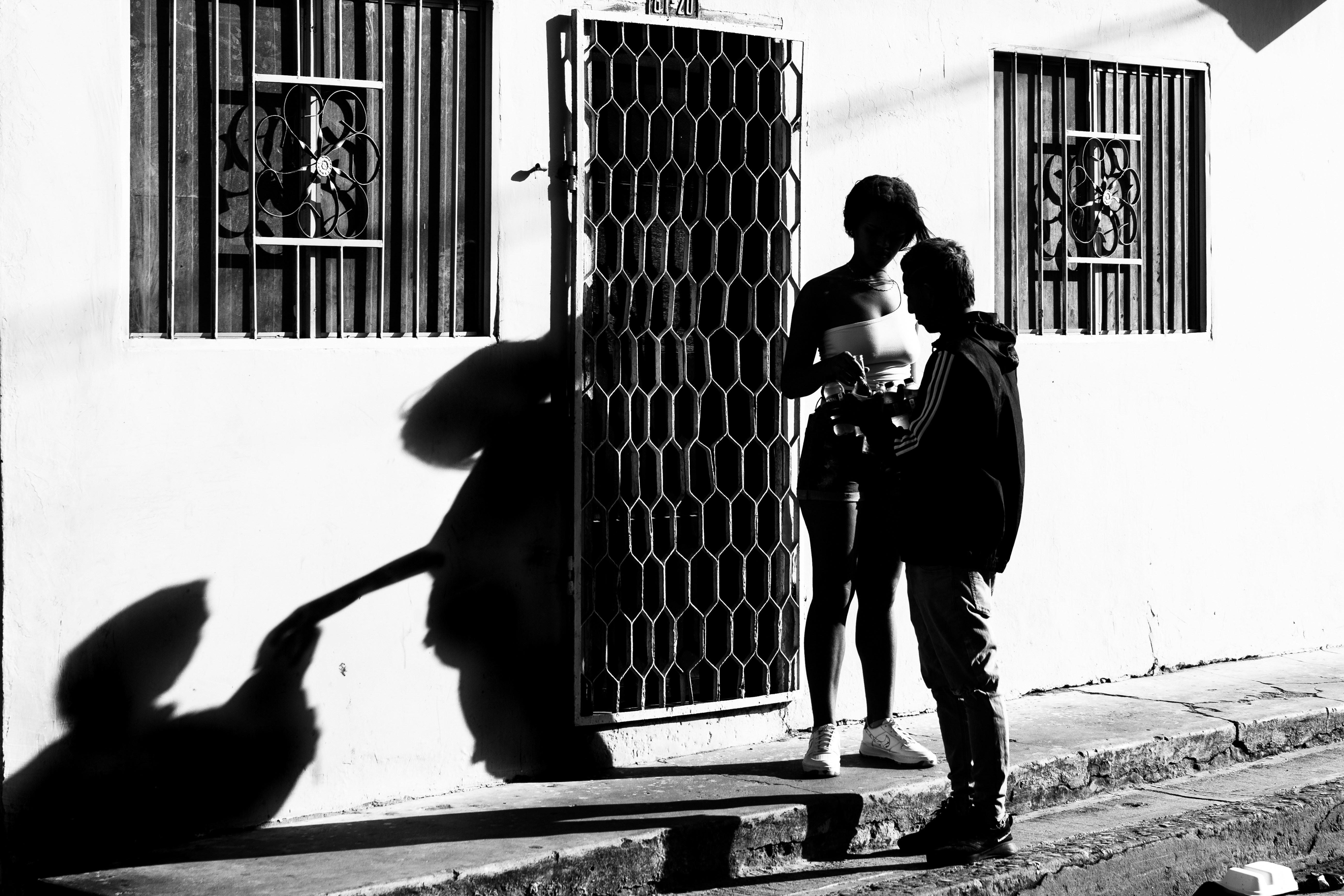 Shadows at the Gate: A Quiet Moment in the Street