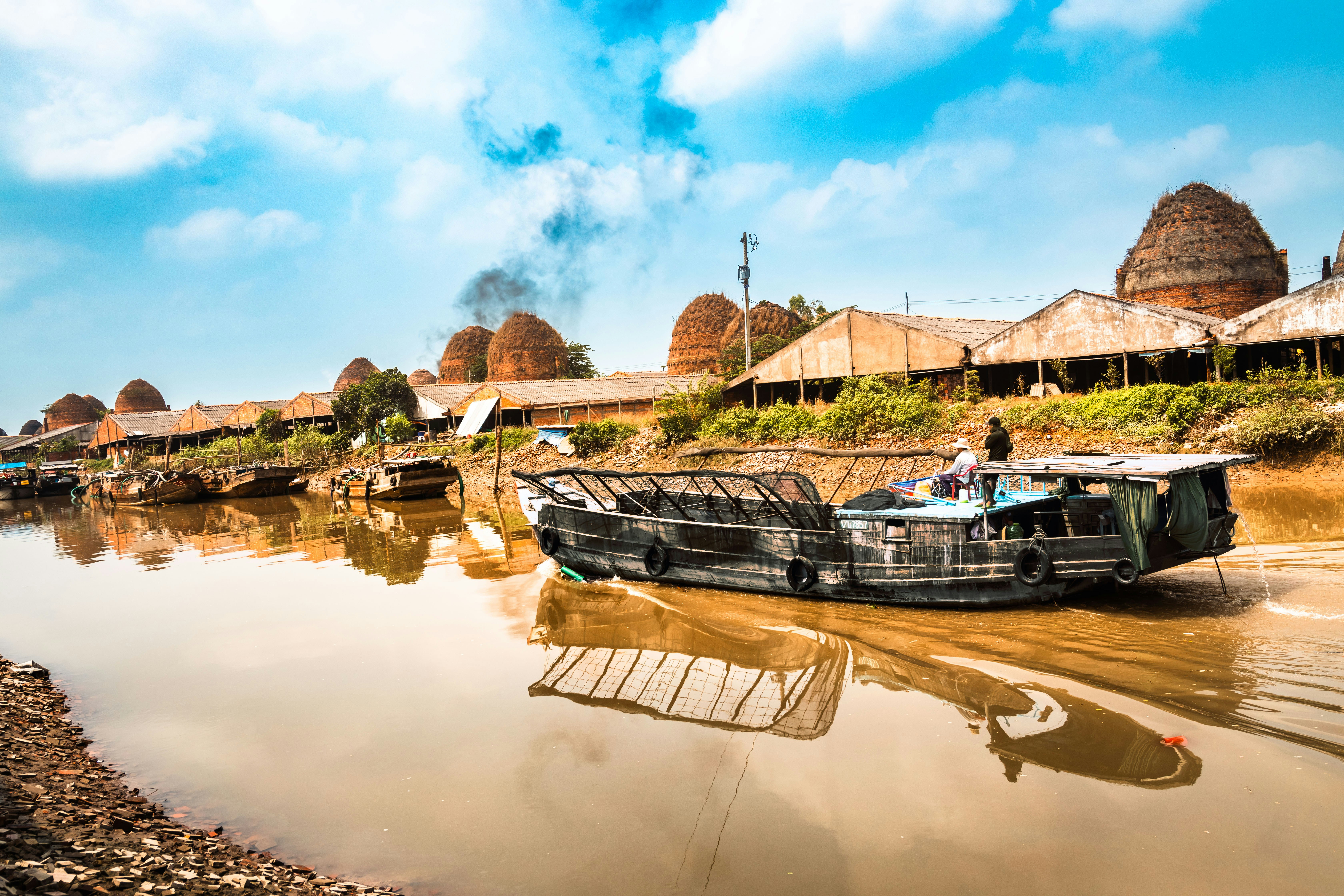 River Barques at Dusk: Boats, Smoke and Mud Reflections