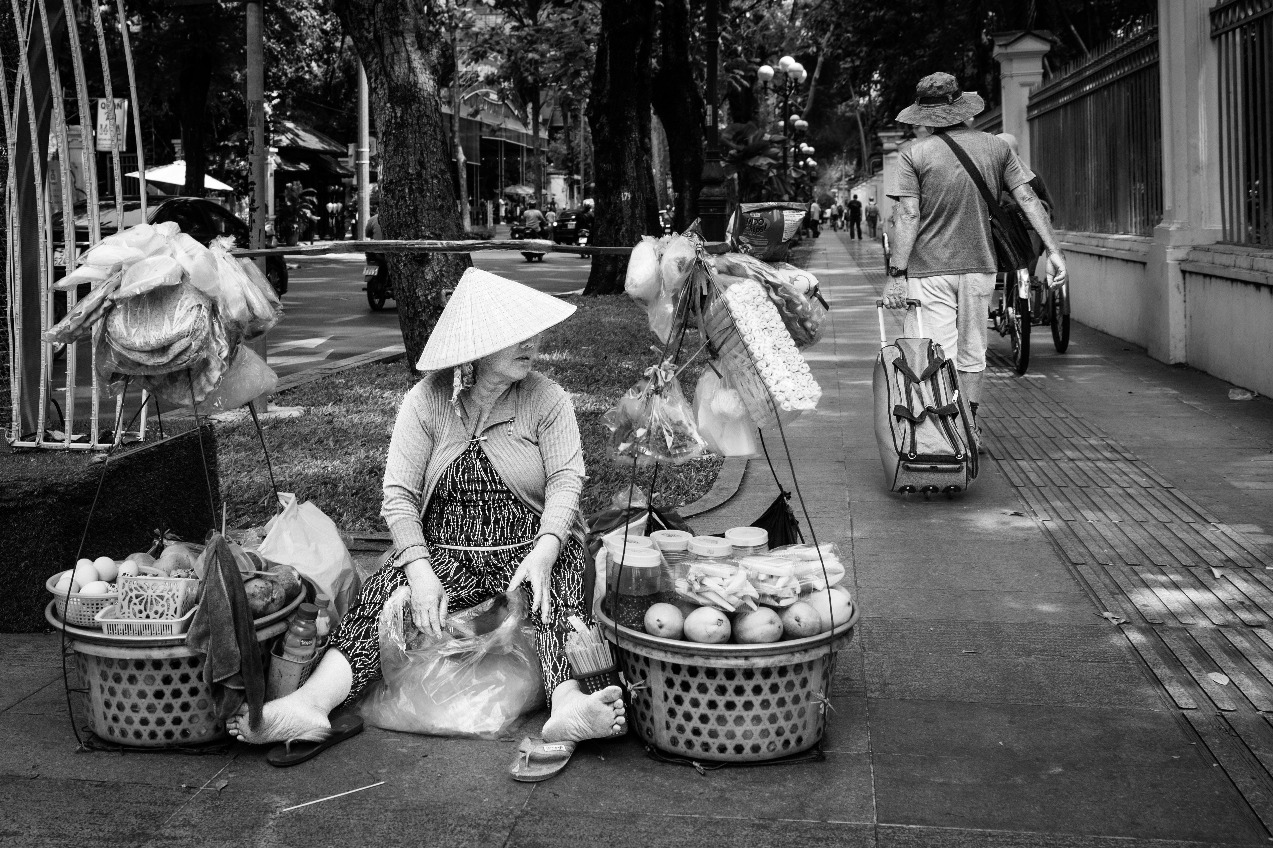 Street Vendor Trio: A Quiet Moment in Black and White