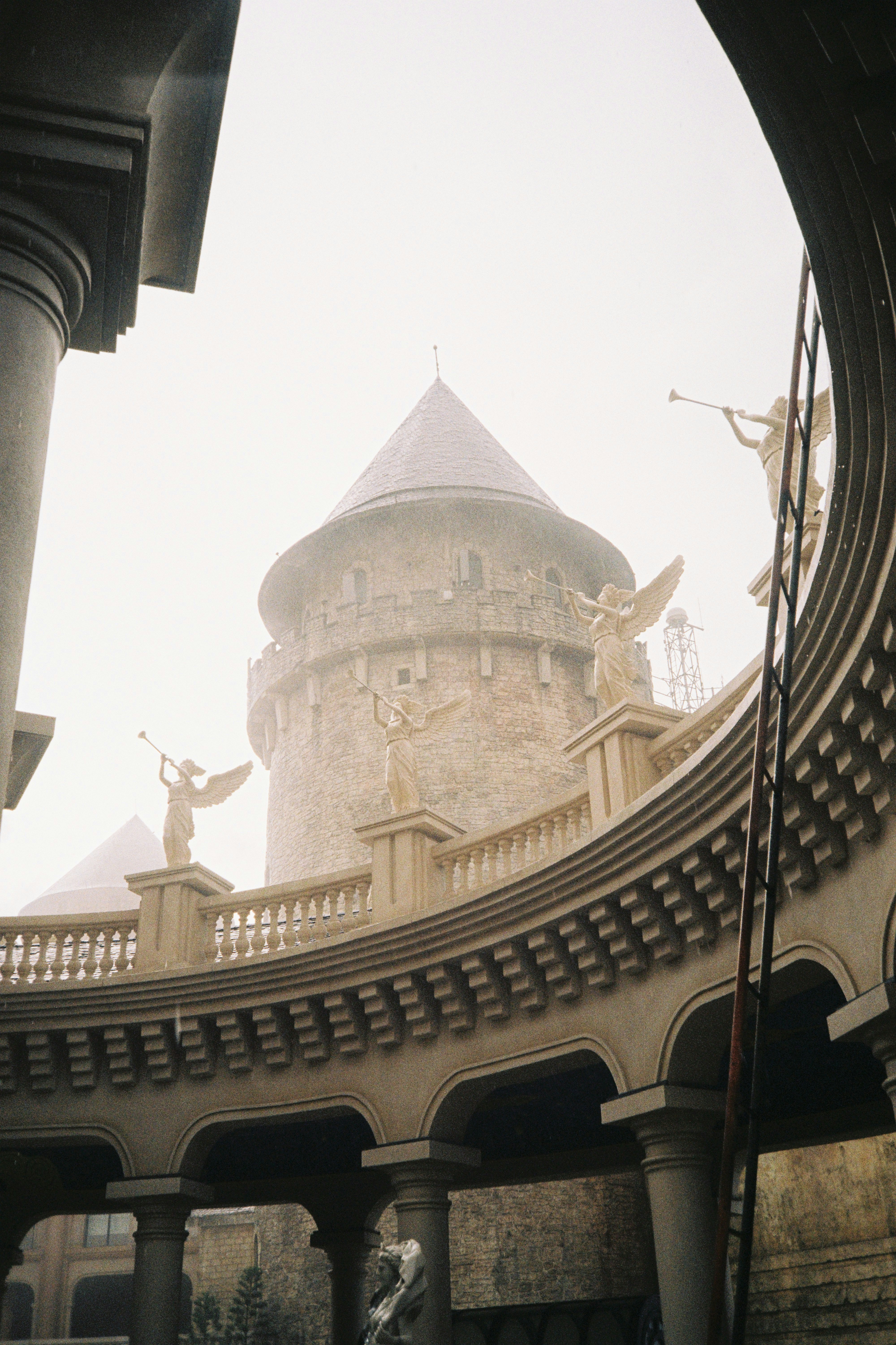 Arcade of Saints: A Sunlit Courtyard Framed by Tower and Stone Archways