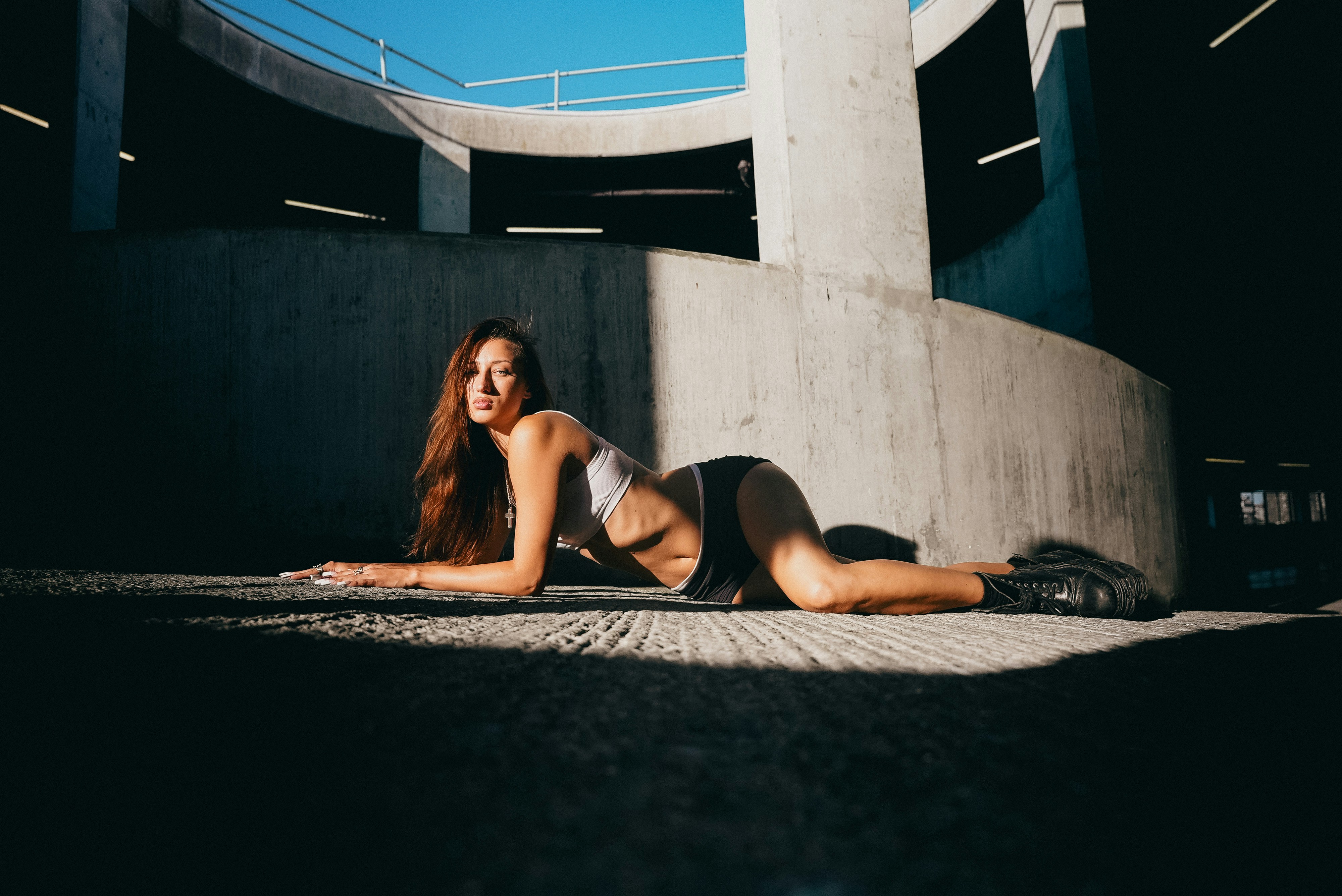 Sunlit Resolve: A Lithe Silhouette Beneath Concrete Sky