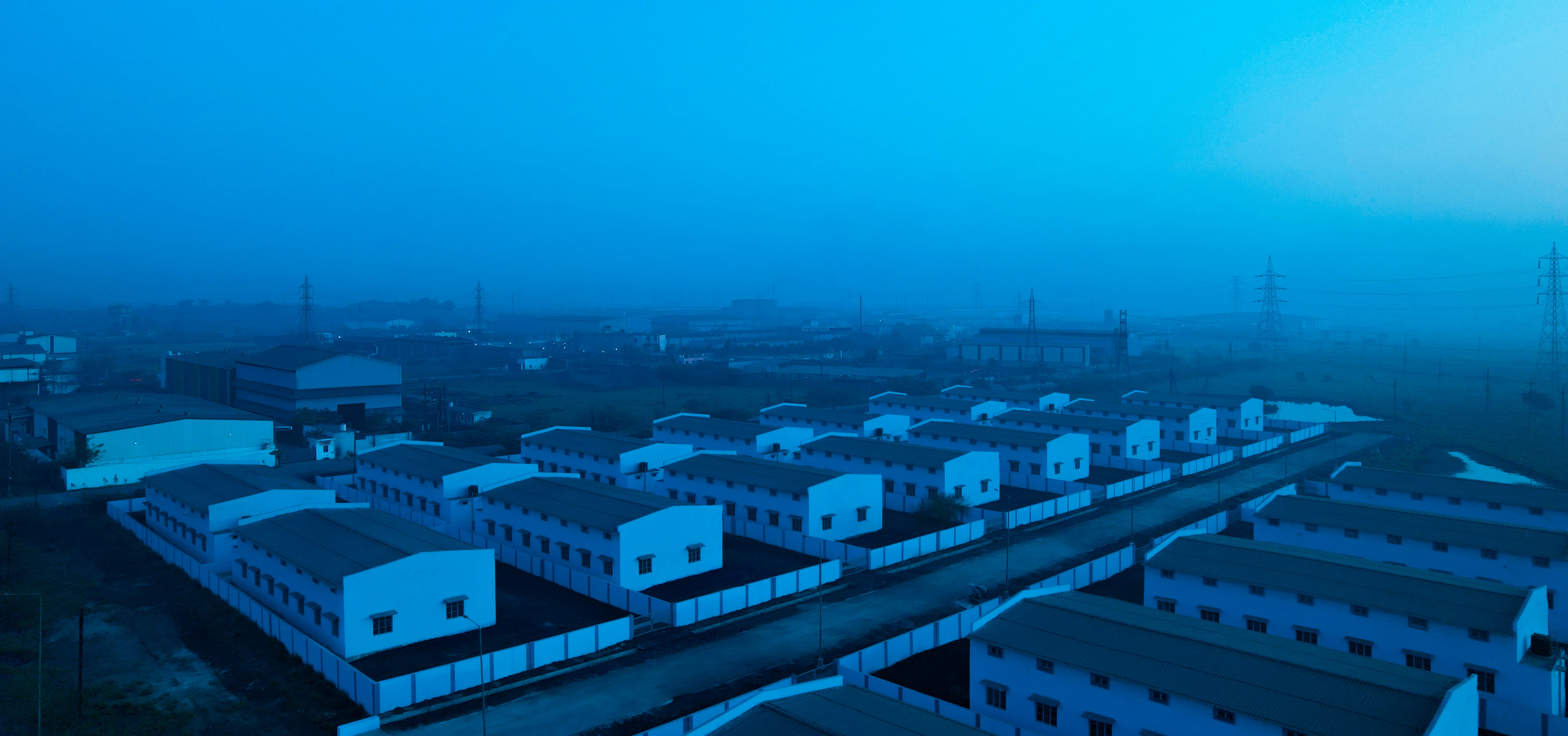 Blue-tinted industrial village under a flat horizon
