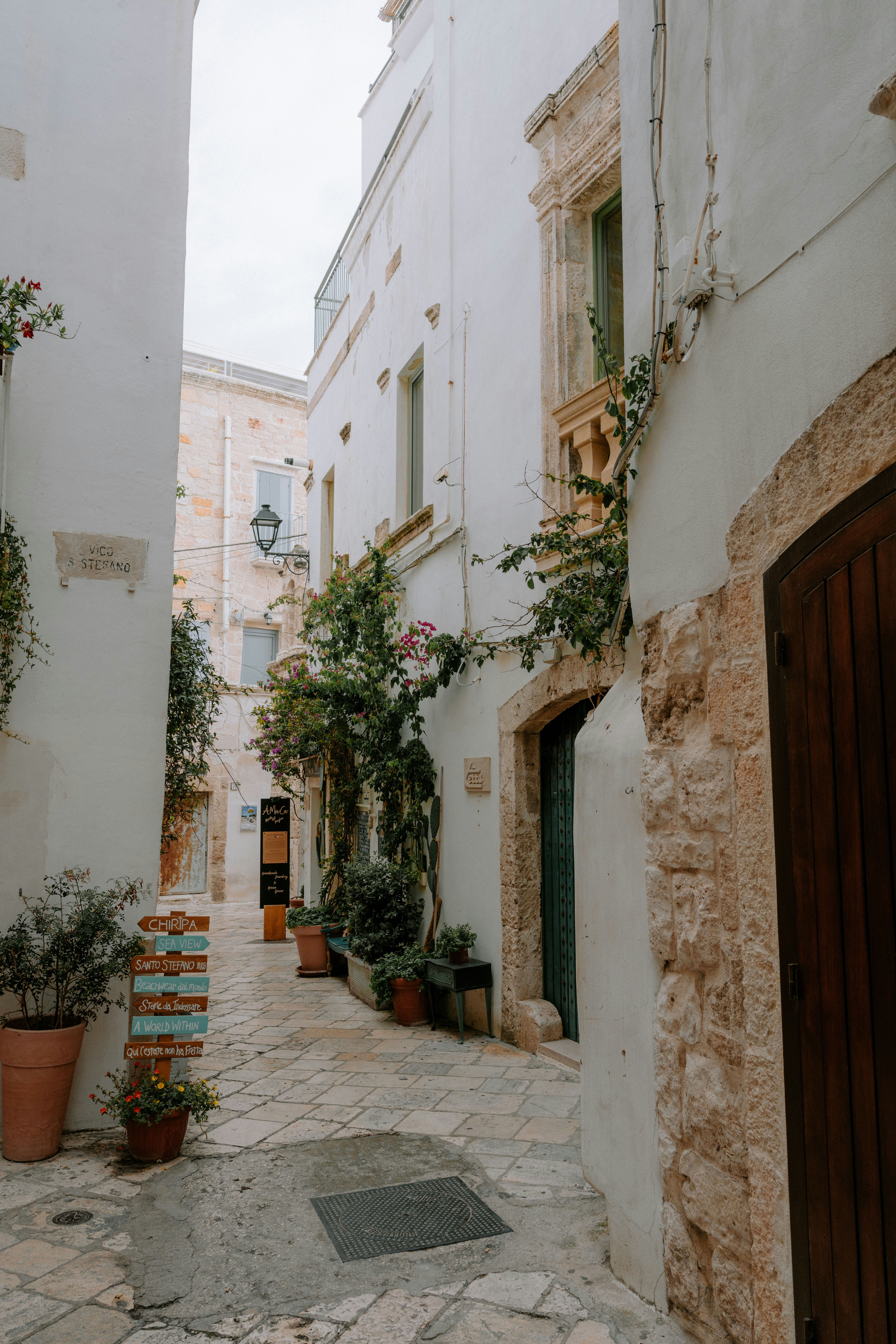 Cobbled Orchard Lane: Sunlit Archways and Greenery Framing a Quiet Alley