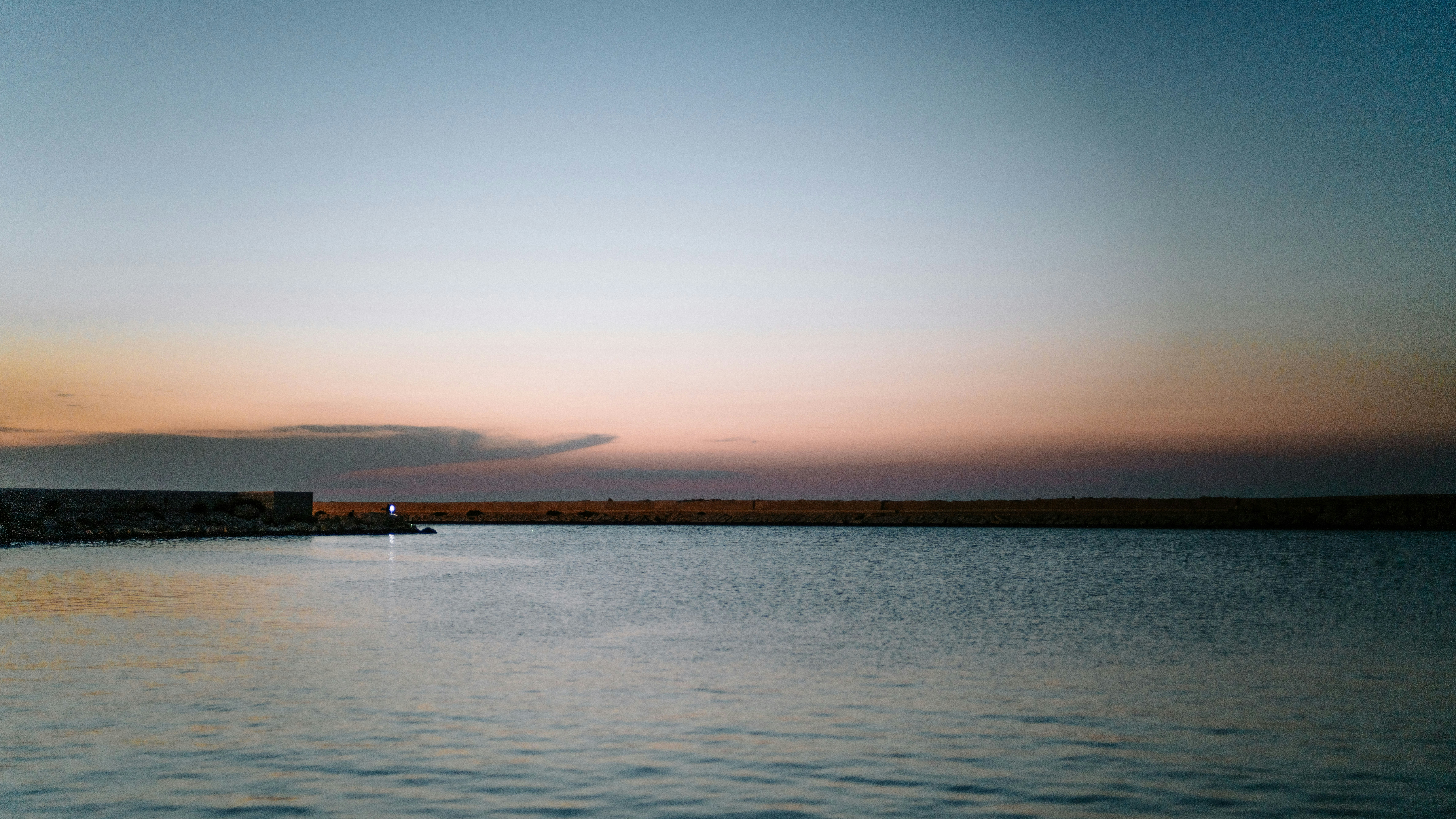 Sunset Over a Calm Breakwater