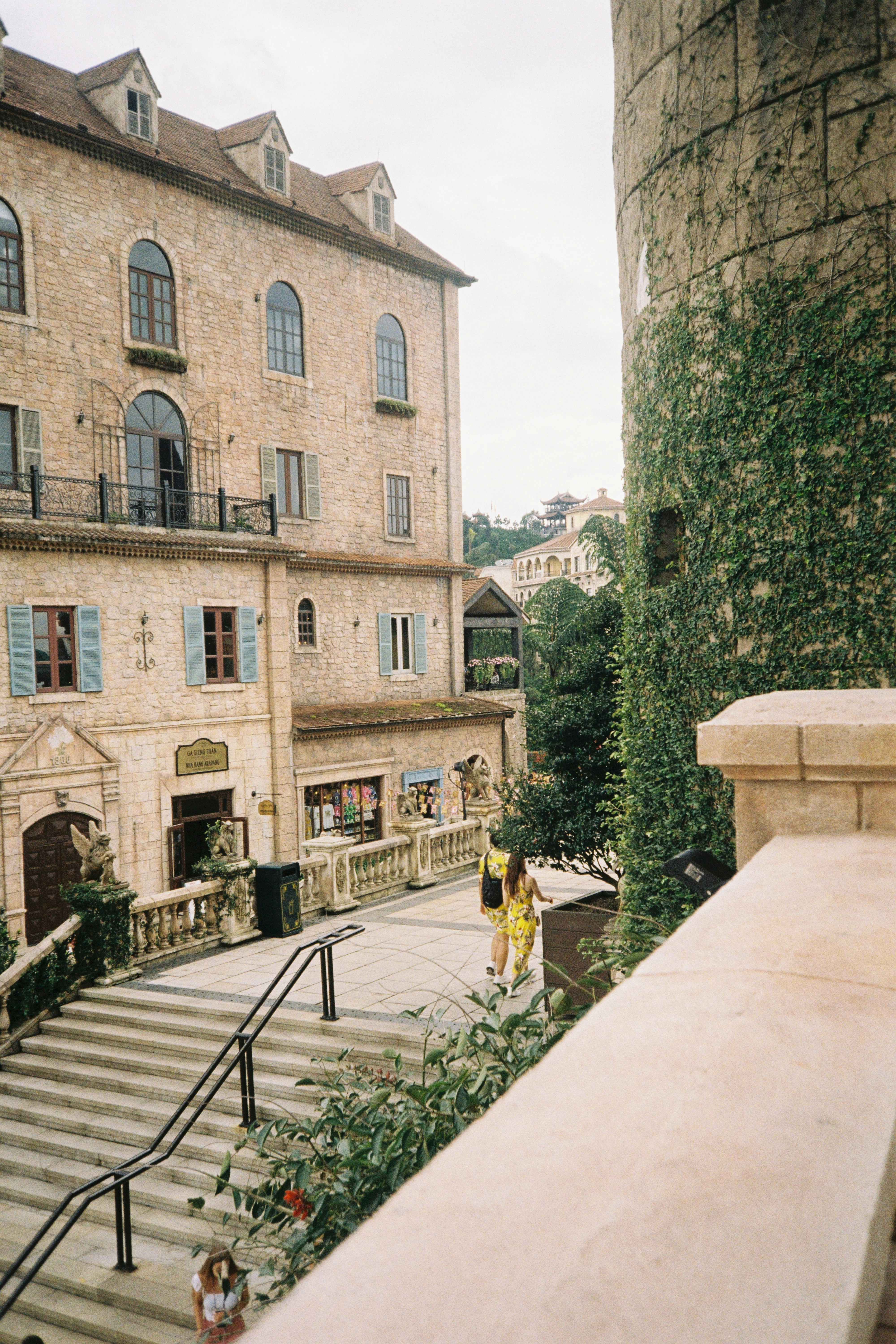 Sunlit Courtyard Descent: Quiet Moment Between Stone Facades