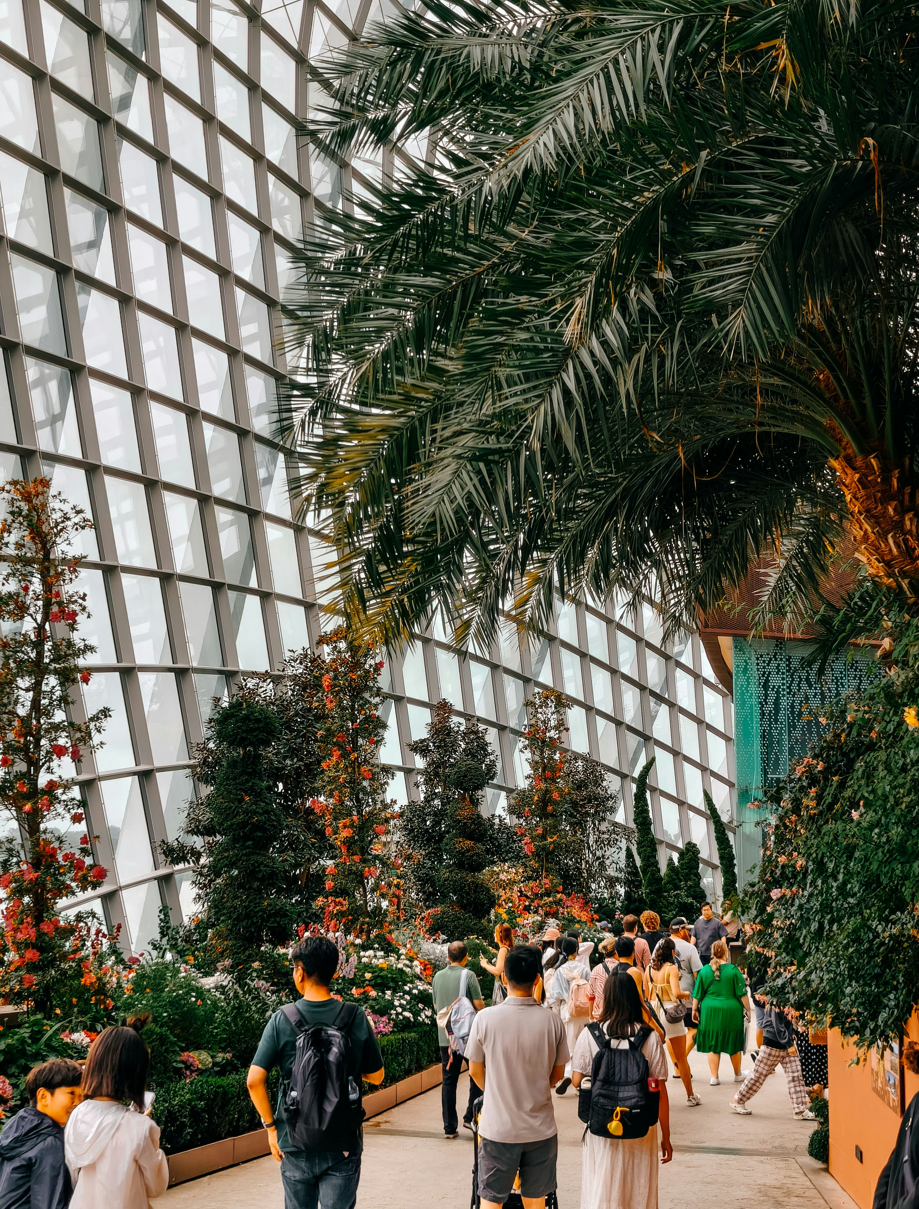 Indoor Garden Corridor Amid Palm Fronds and Visitors