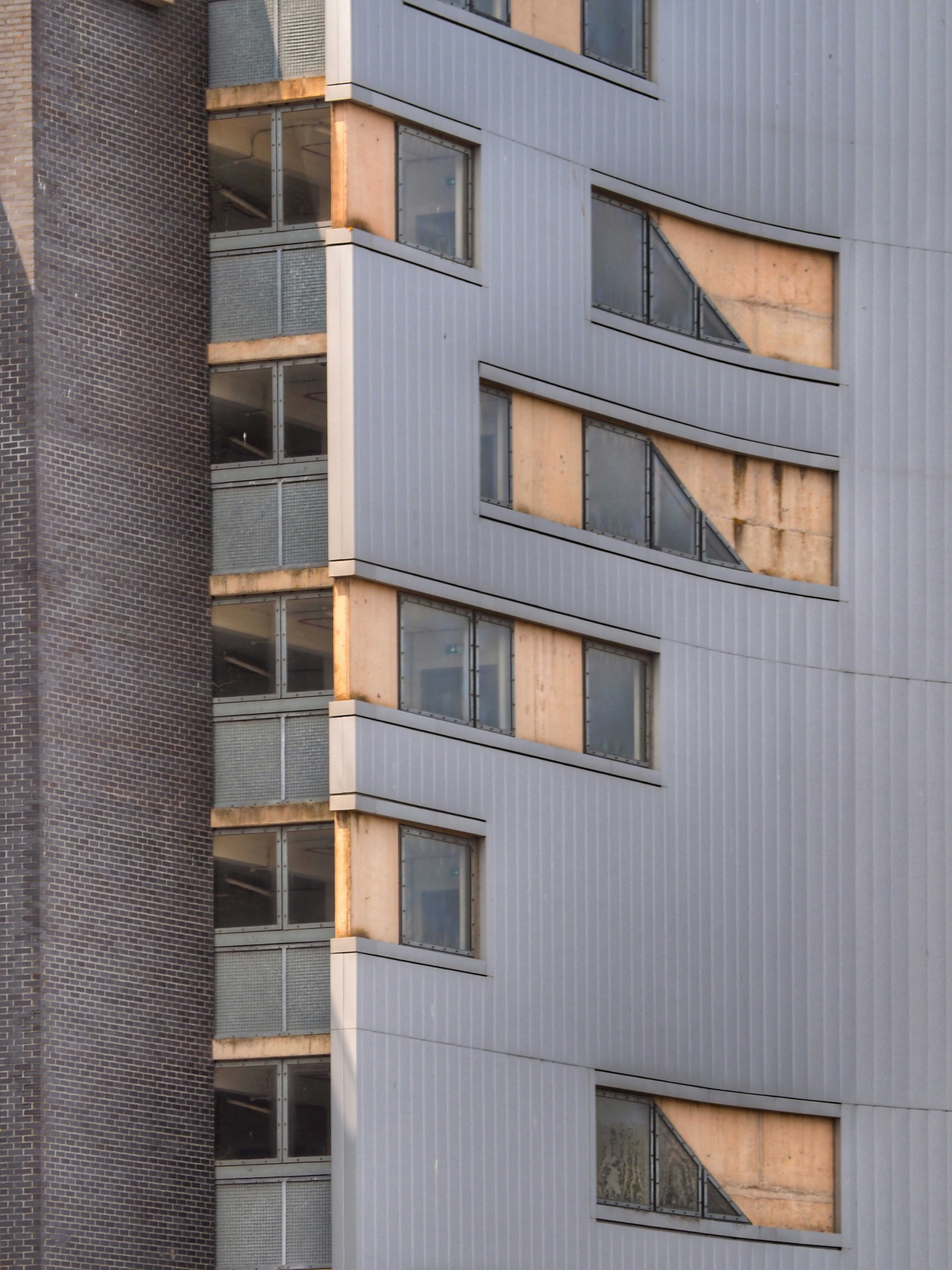 Vertical Facade: Light and Shadow Play on a Modern Brick-and-Metal Building