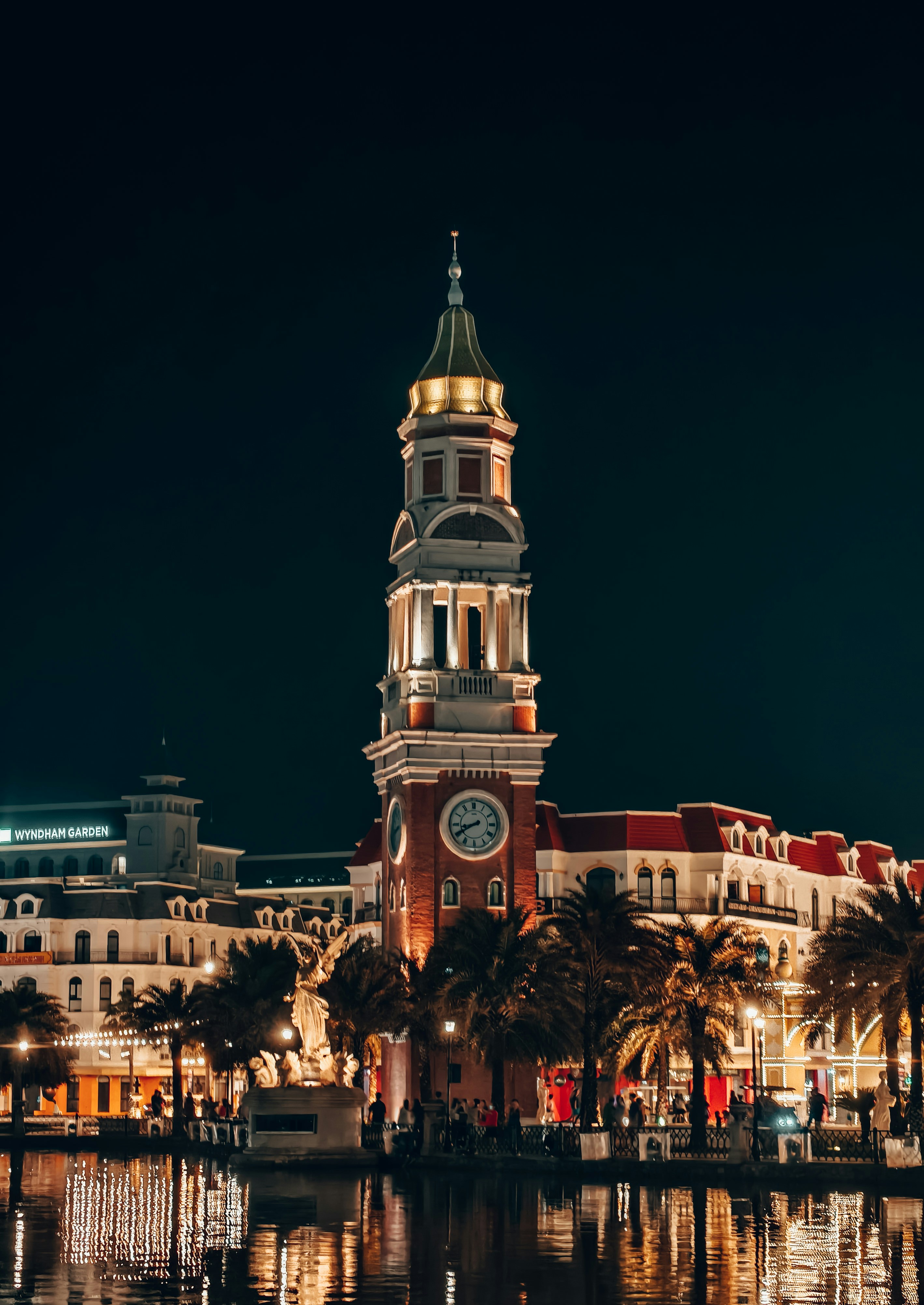 Towered Clock in a Luminescent Night Harbor