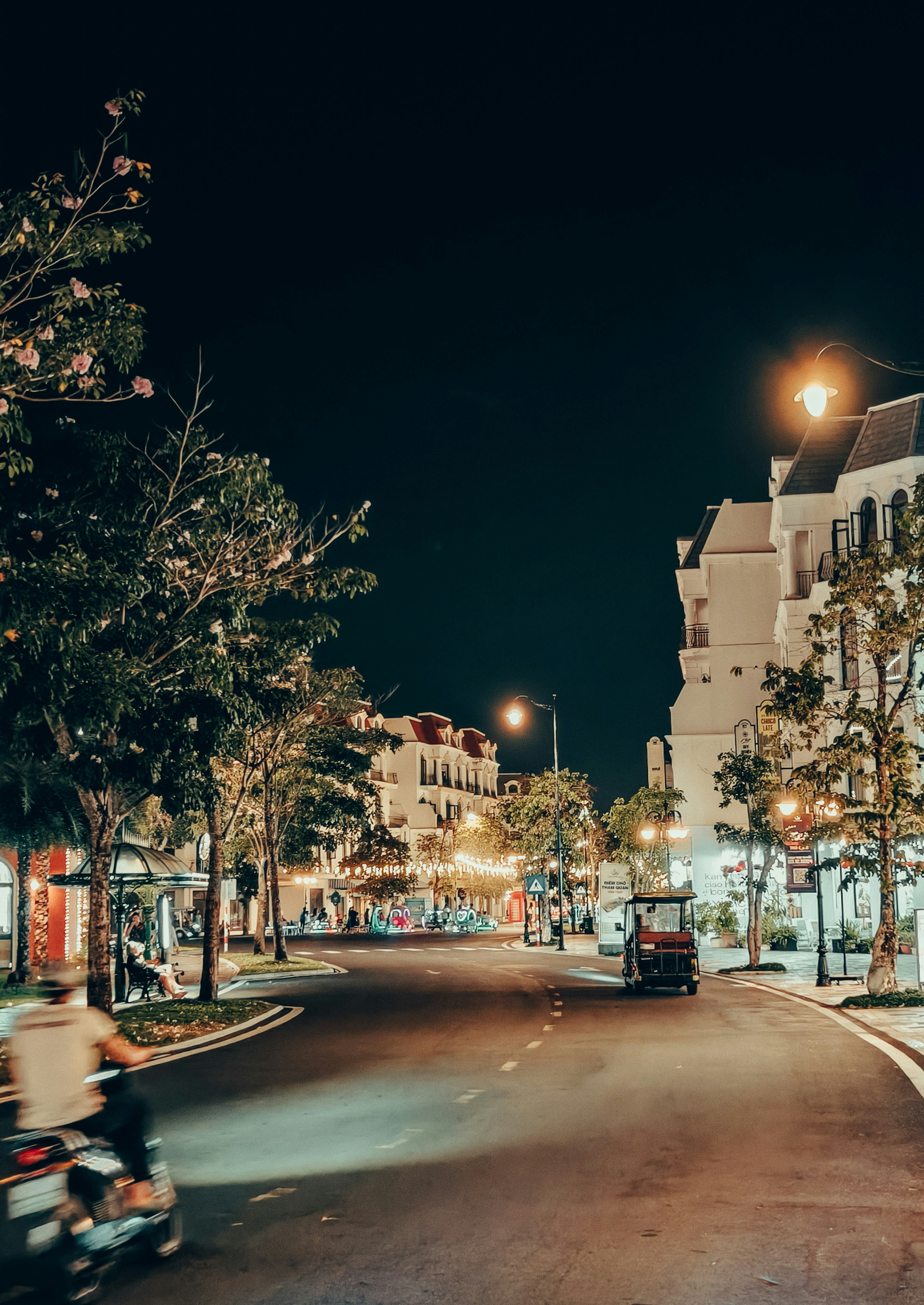 Night Streetlum: Warm streetlights and moving silhouettes under a velvet city sky