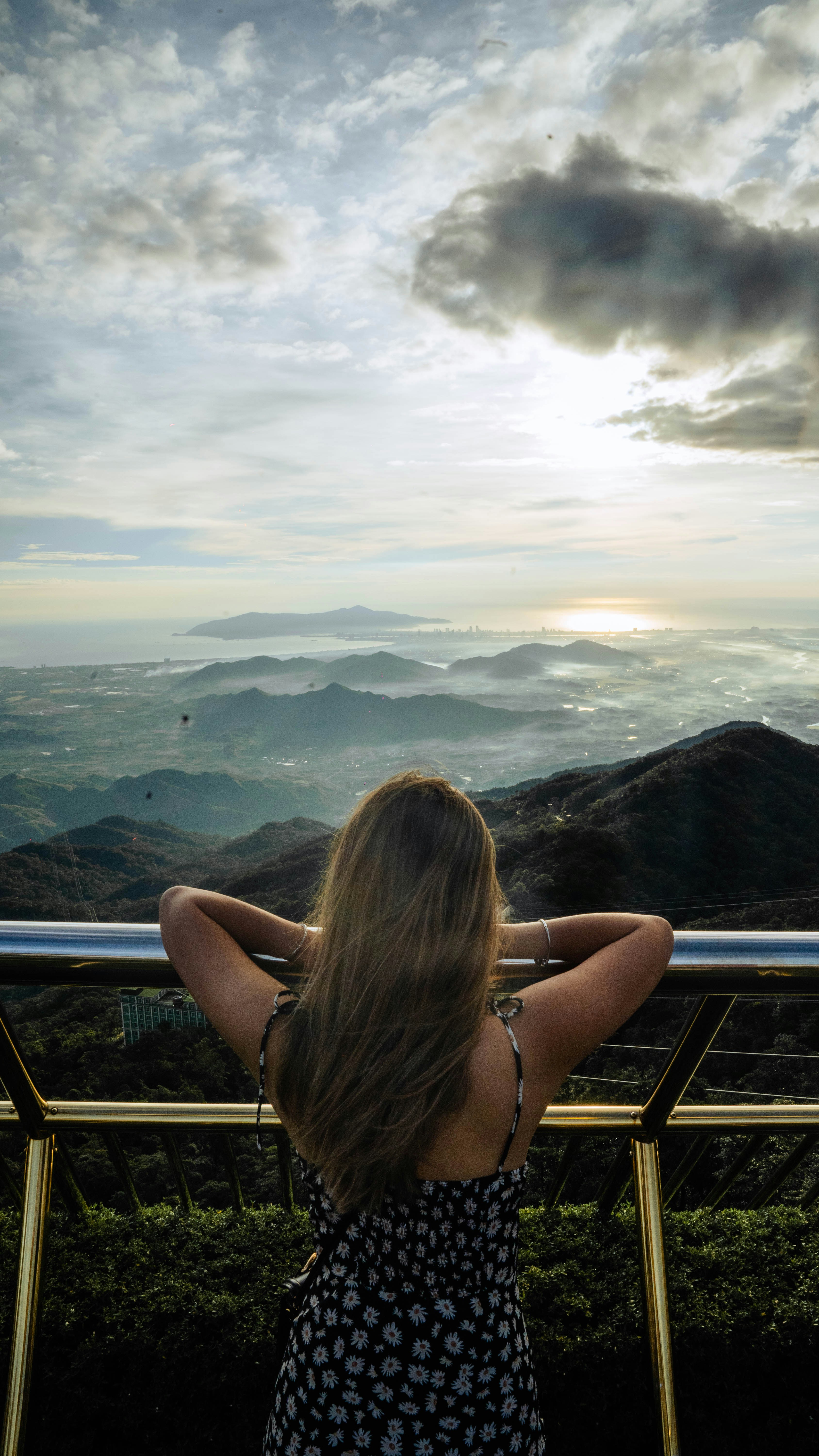 Overlook from the Summit: A Woman Gaze Over Sunrise Valleys