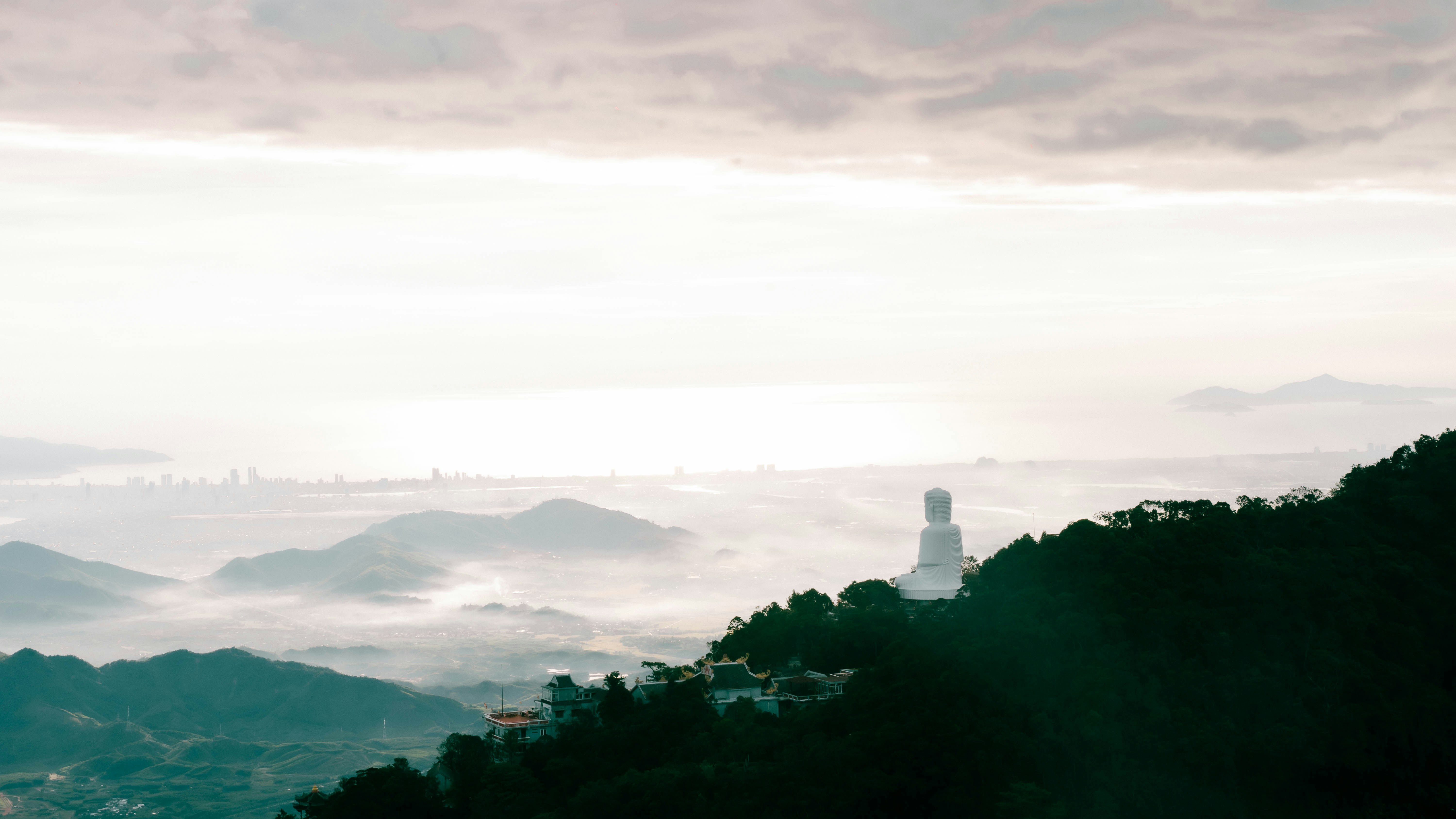 Mist Over the Ridge: A Quiet Buddhist Complex Silhouetted Against a Cloudy Horizon