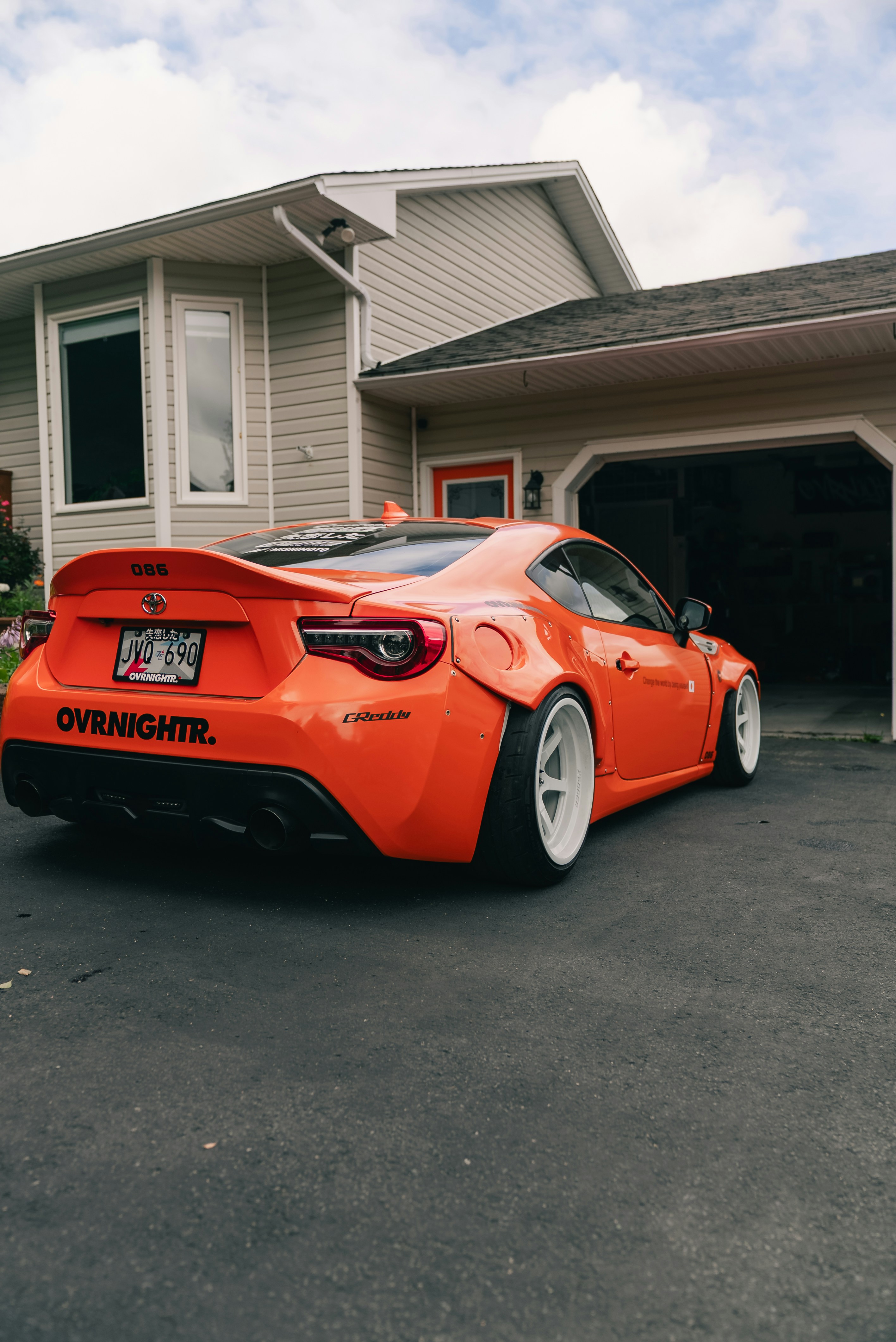 Orange Drift: A Low-Slung Speedster in Front of a Suburban Garage