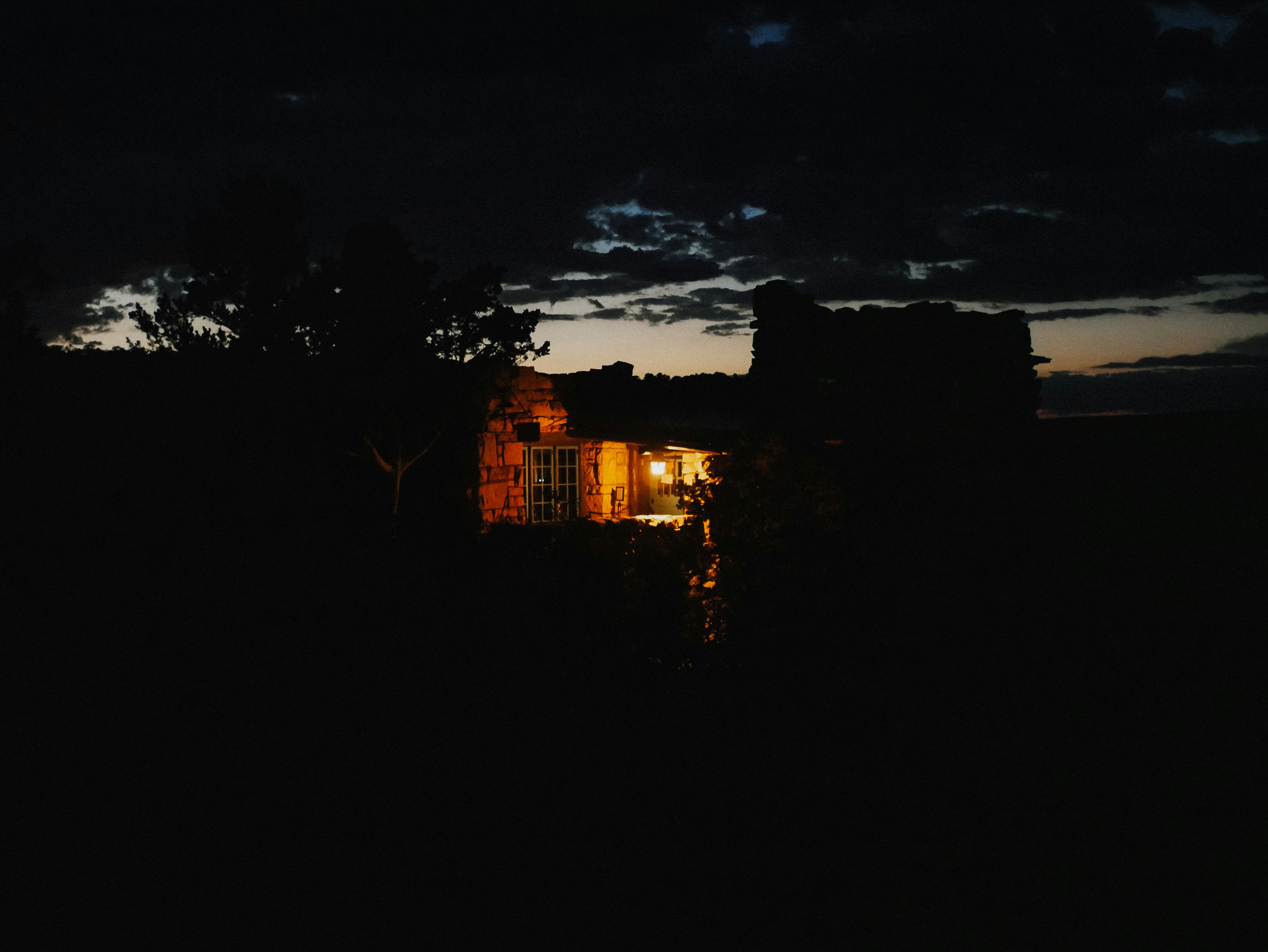Warm Light in the Ruins: A Quiet Occupied Doorway at Dusk