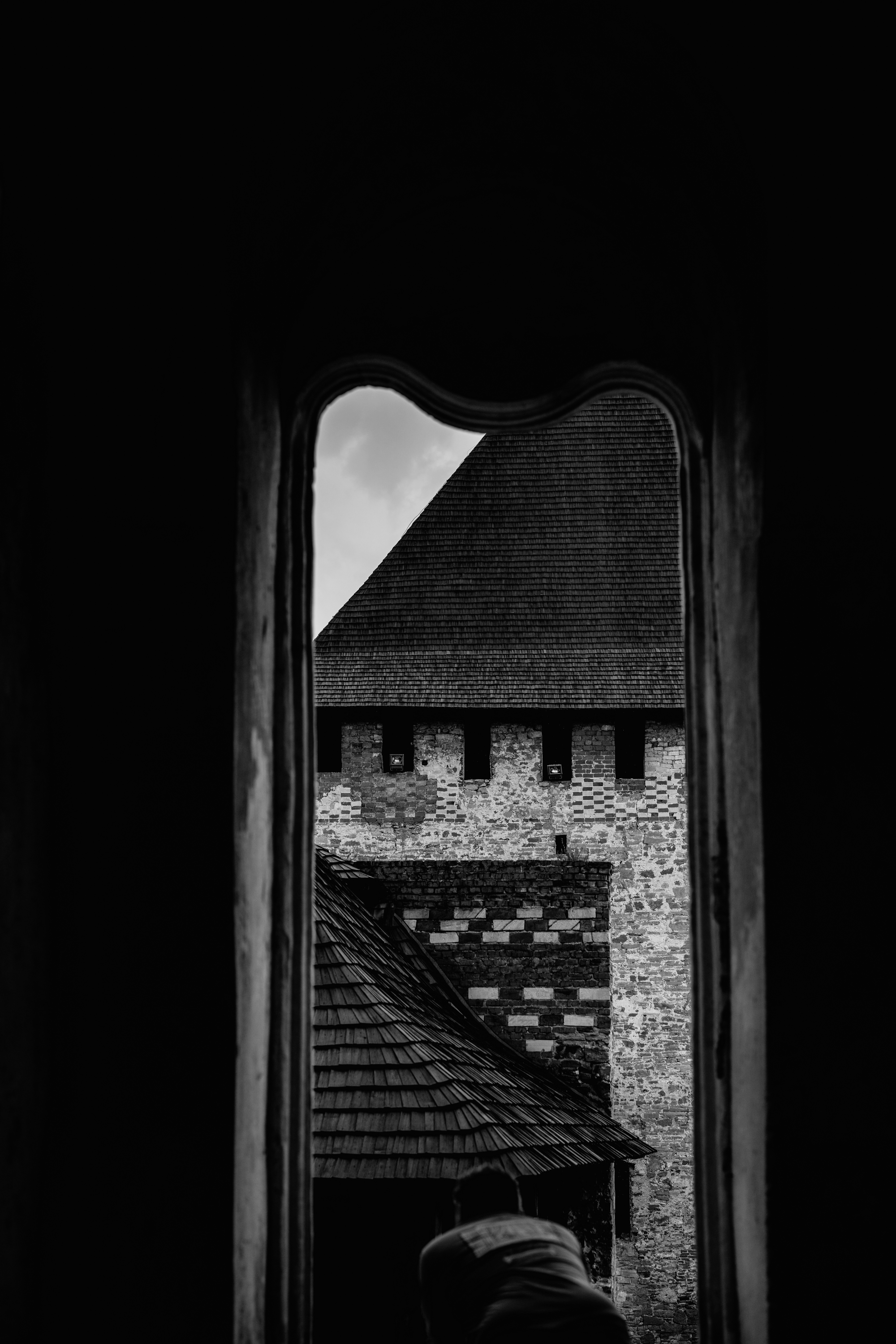 Through a Narrow Arch: Medieval Facade Framed by Darkness