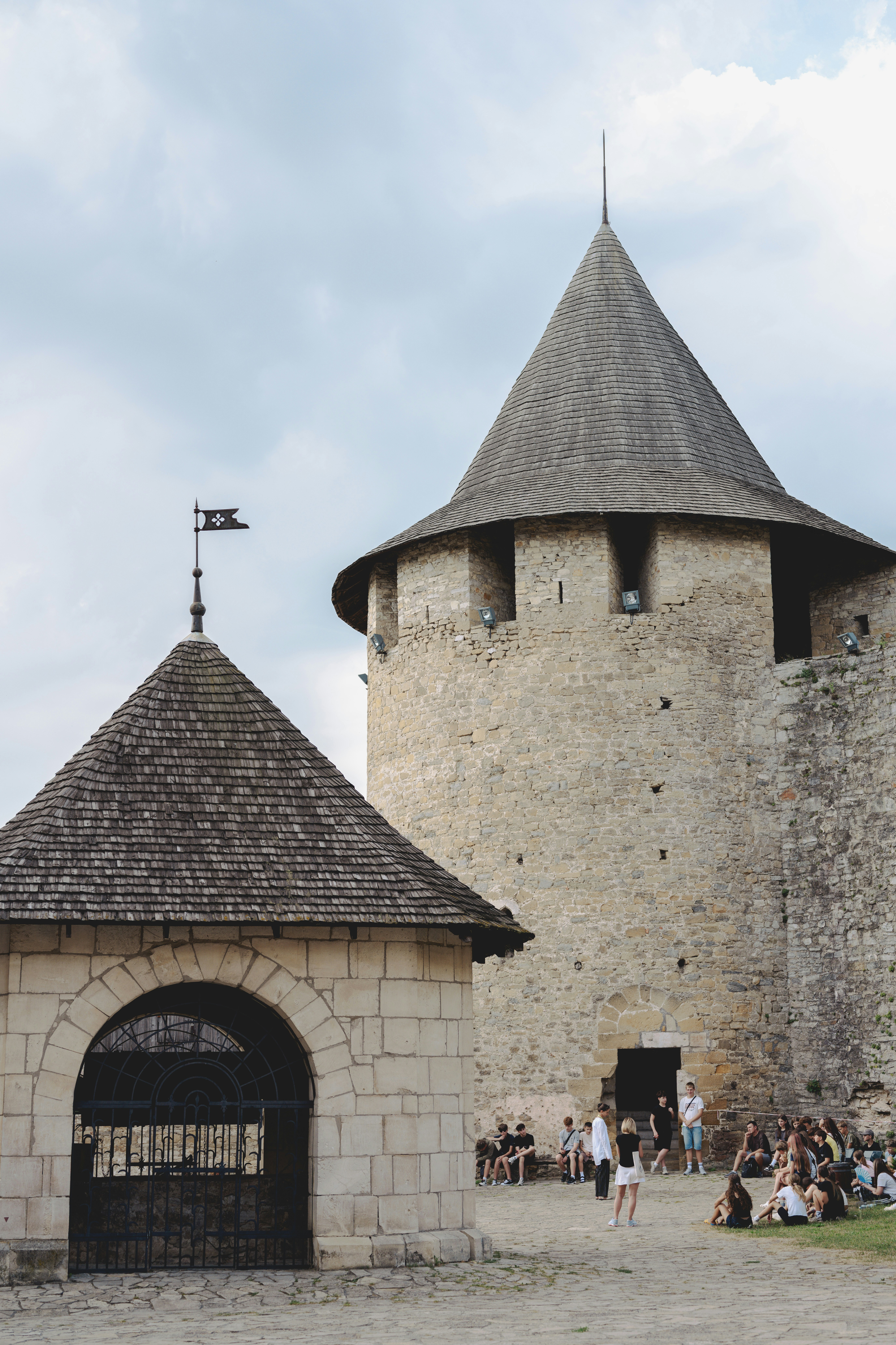 Castle Courtyard: Tourists Gather at the Gate Beneath Towering Turrets