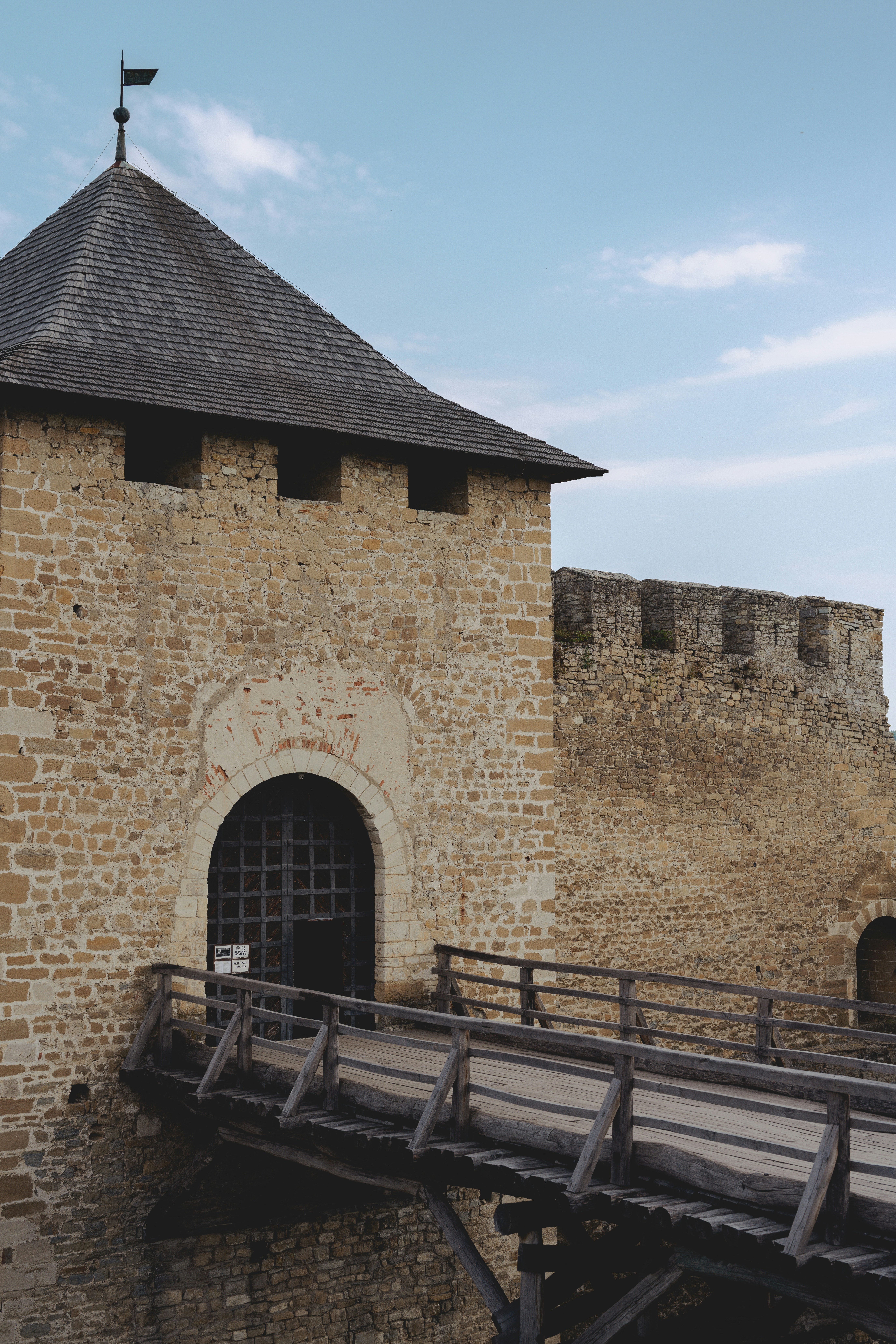 Stone Fortress Gate Framed by a Weathered Bridge over Quiet Moat