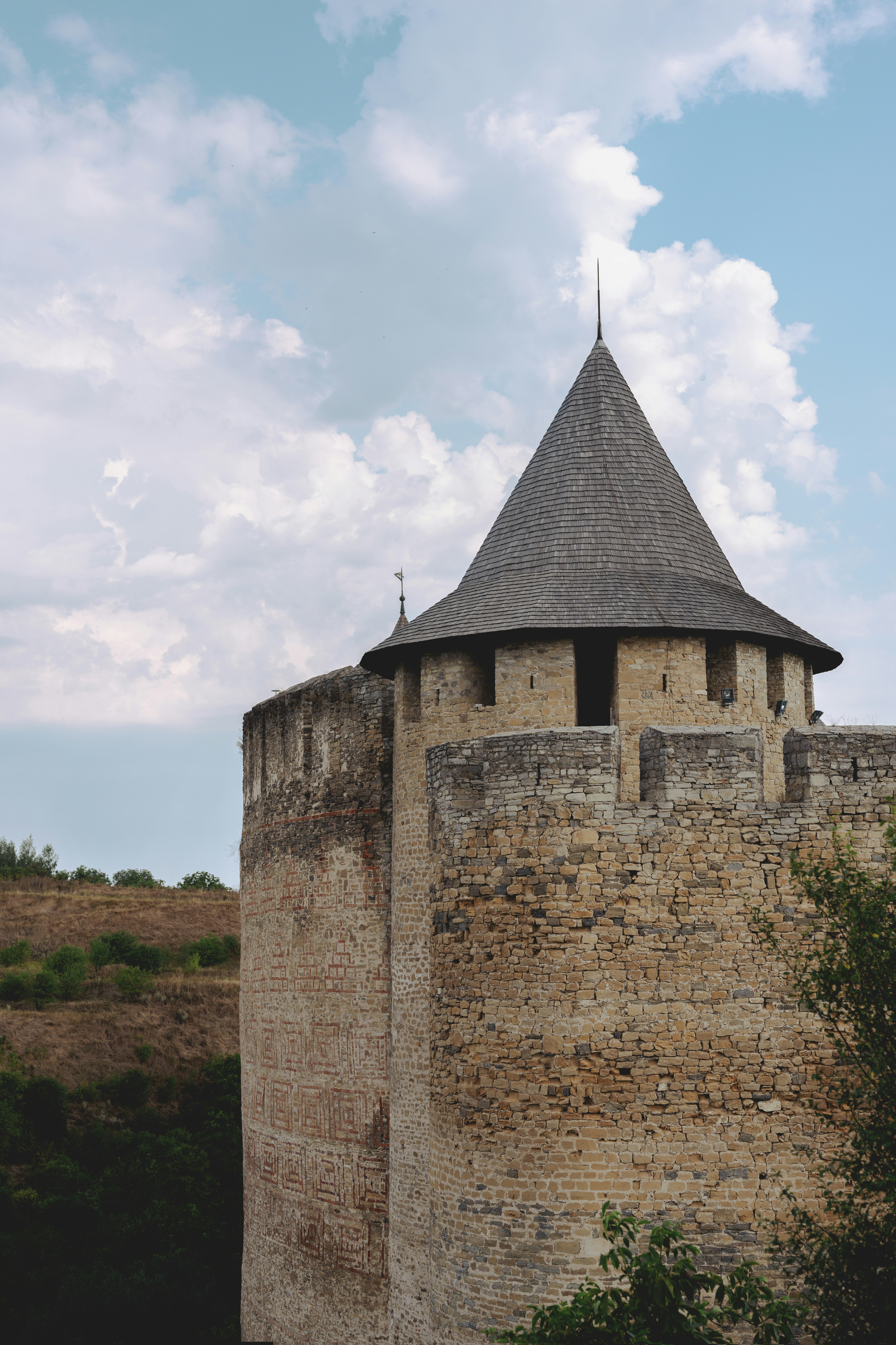 Stone Citadel Crowned by a Conical Roof Against a Clouded Sky