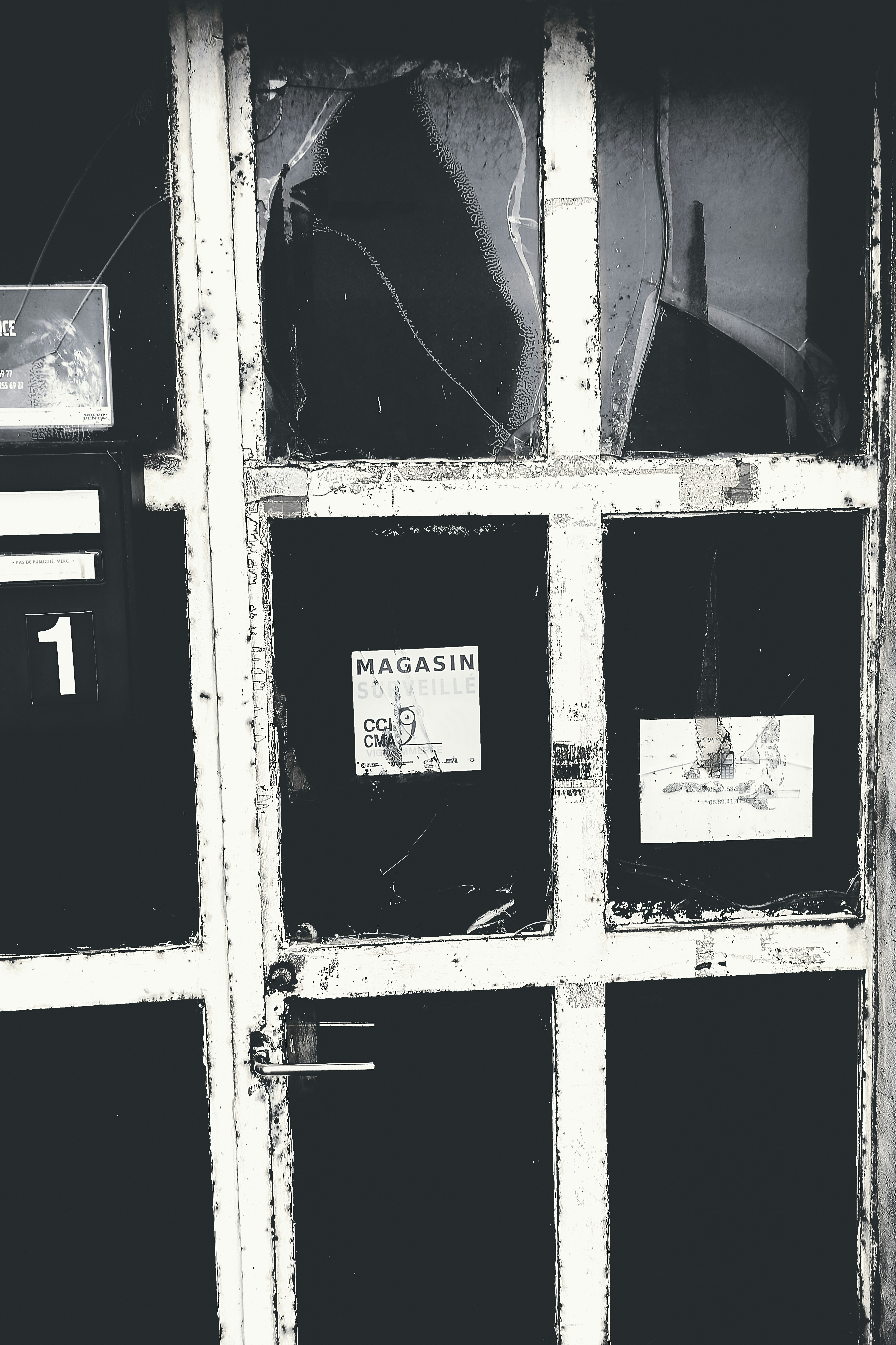 Abandoned Mailbox Fragments: Cracked Glass and Weathered Door Panels