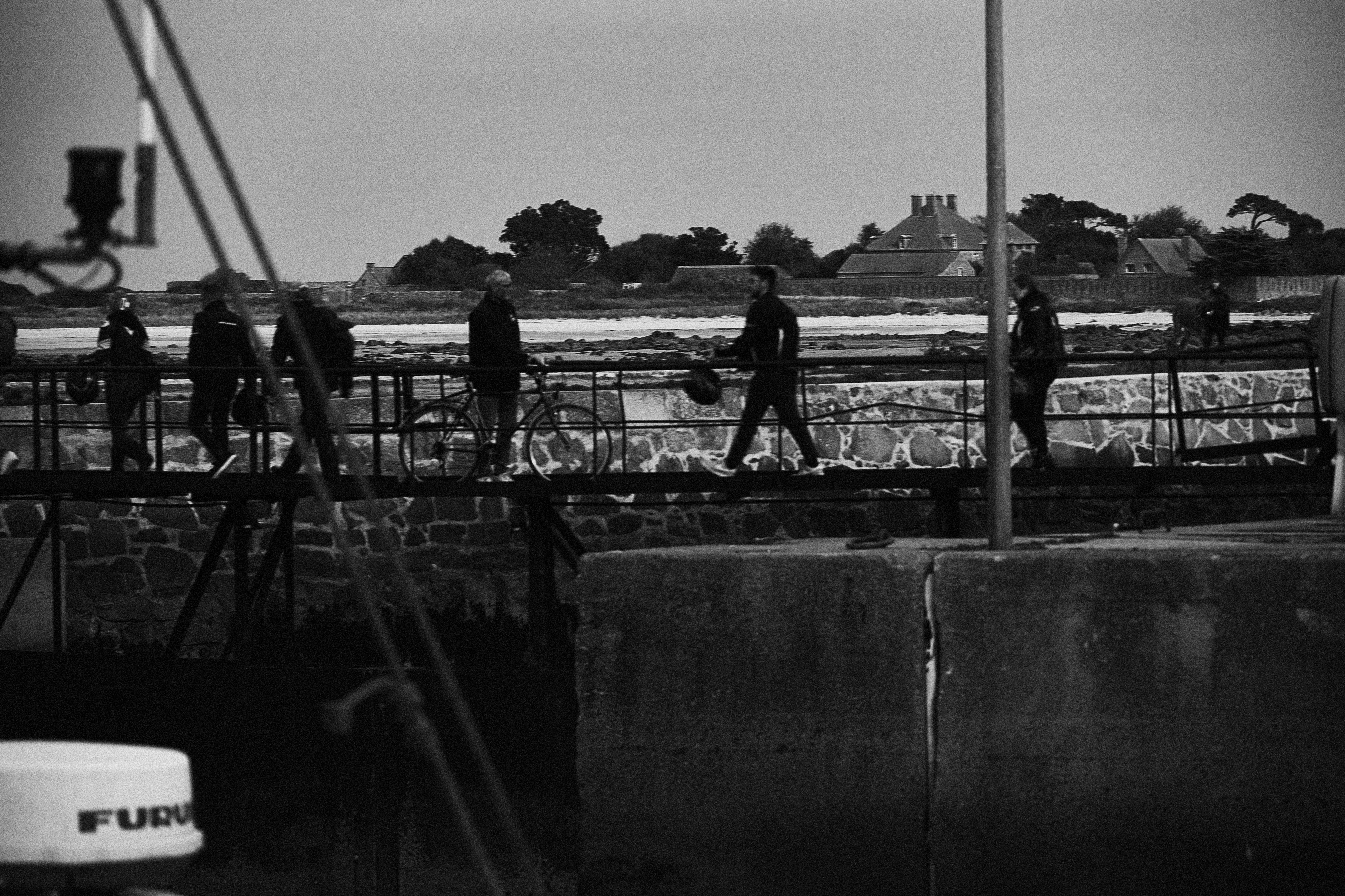 Silhouettes on the Pier: A Monochrome Stroll