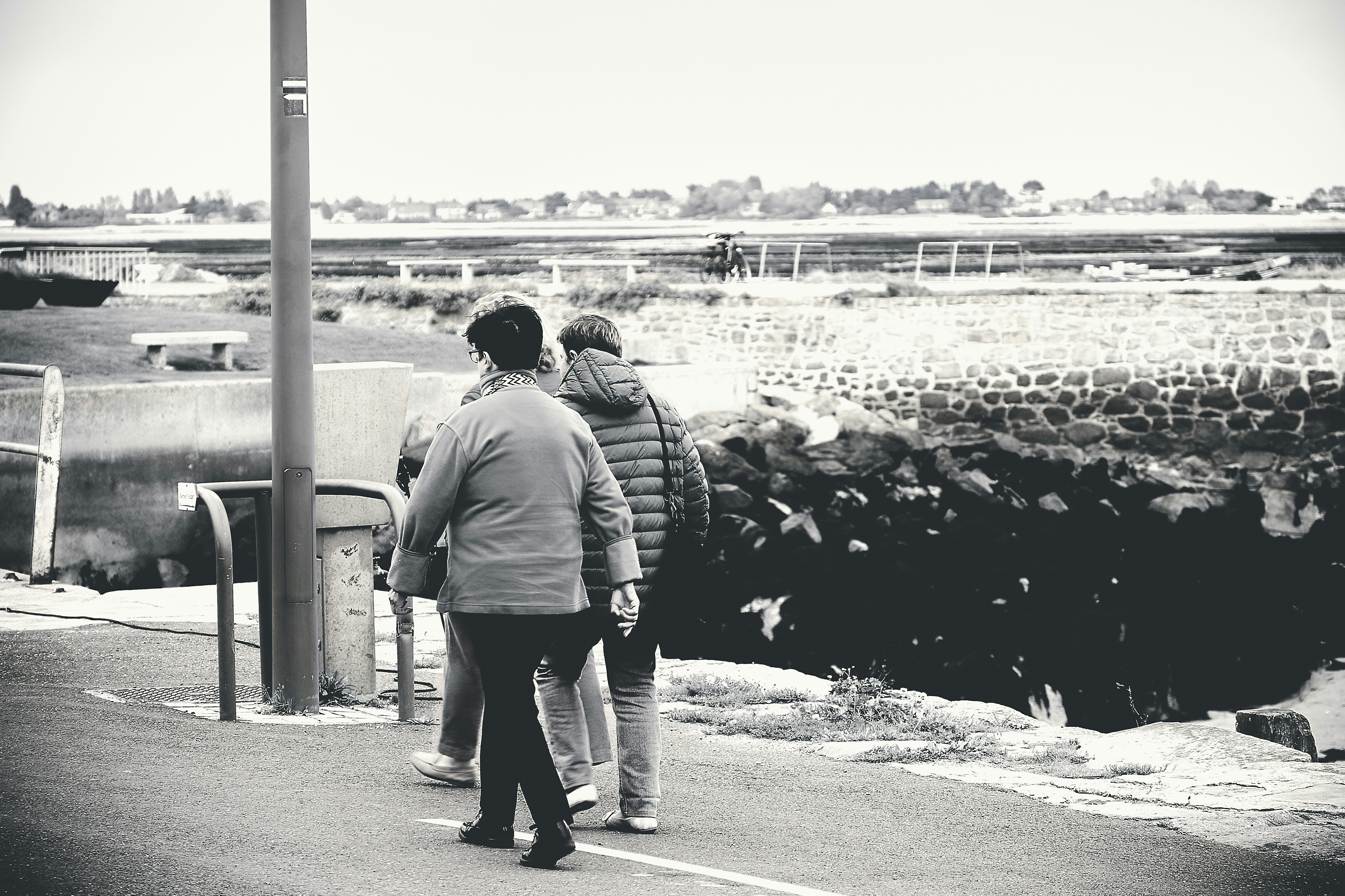 Two Walkers Along a Tranquil Waterfront