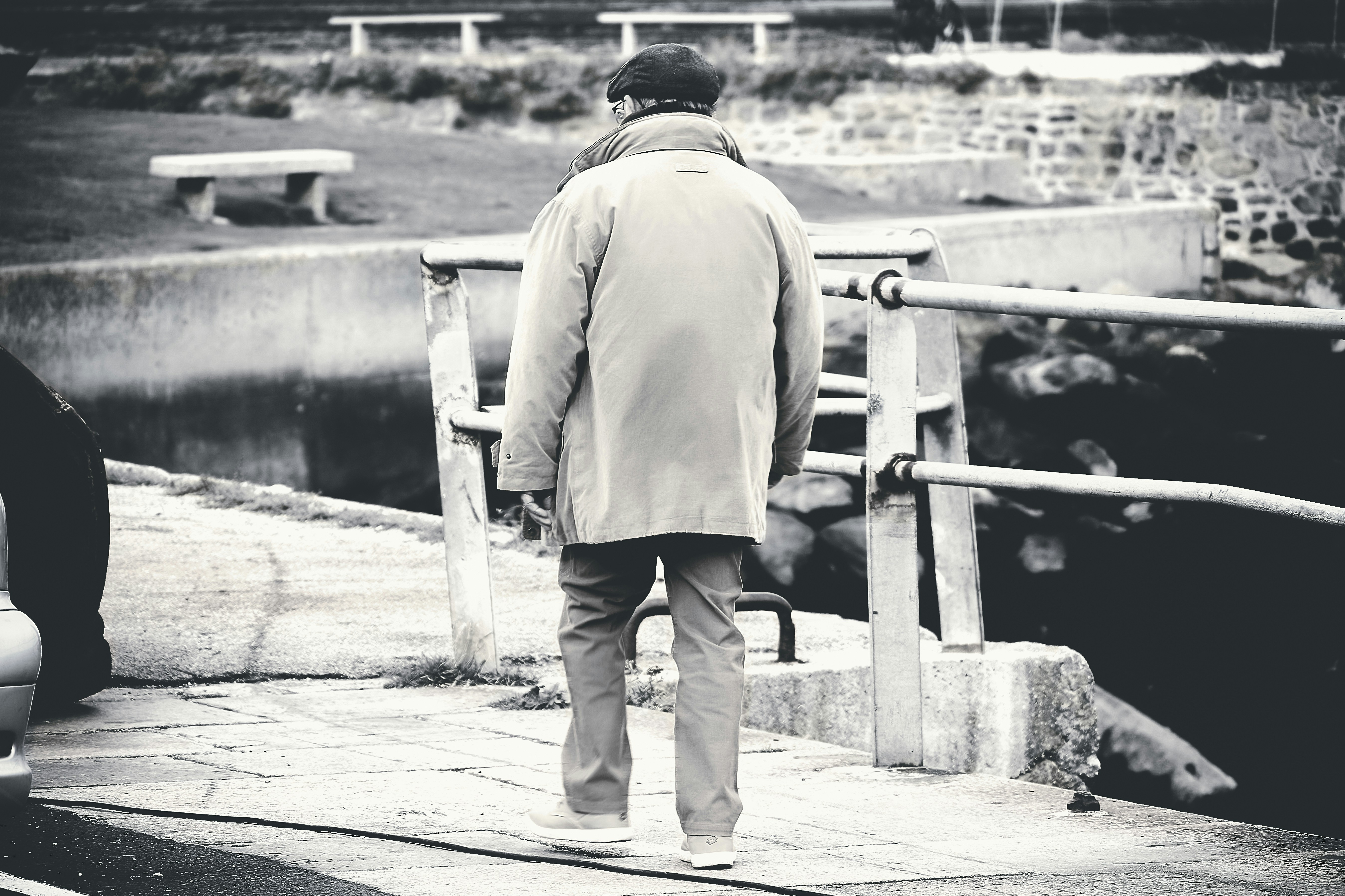 Quiet Return: A Man in a Light Coat at the Harbor's Edge