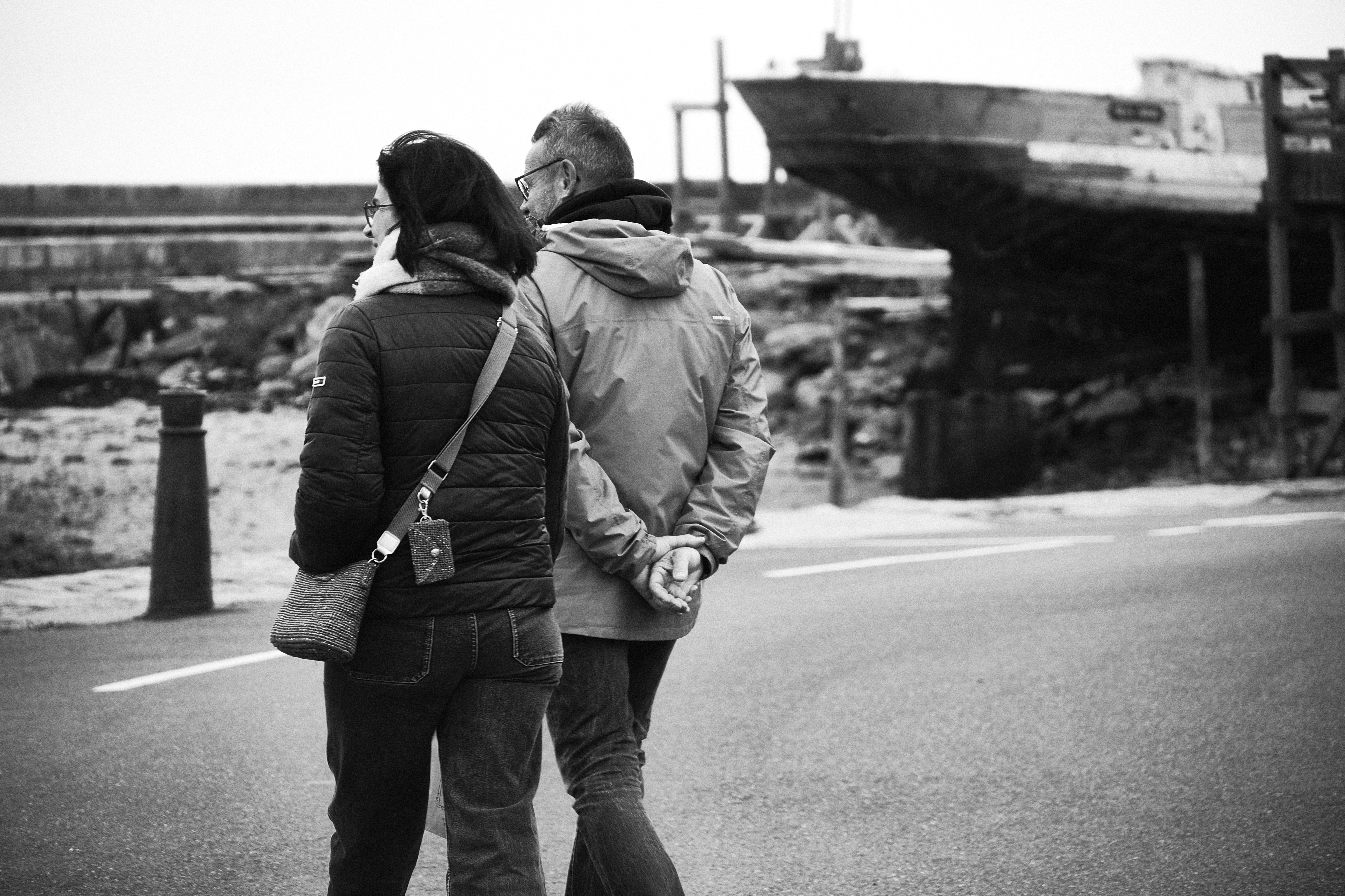 Two Wanderers in Black and White by a Harbor Ruin
