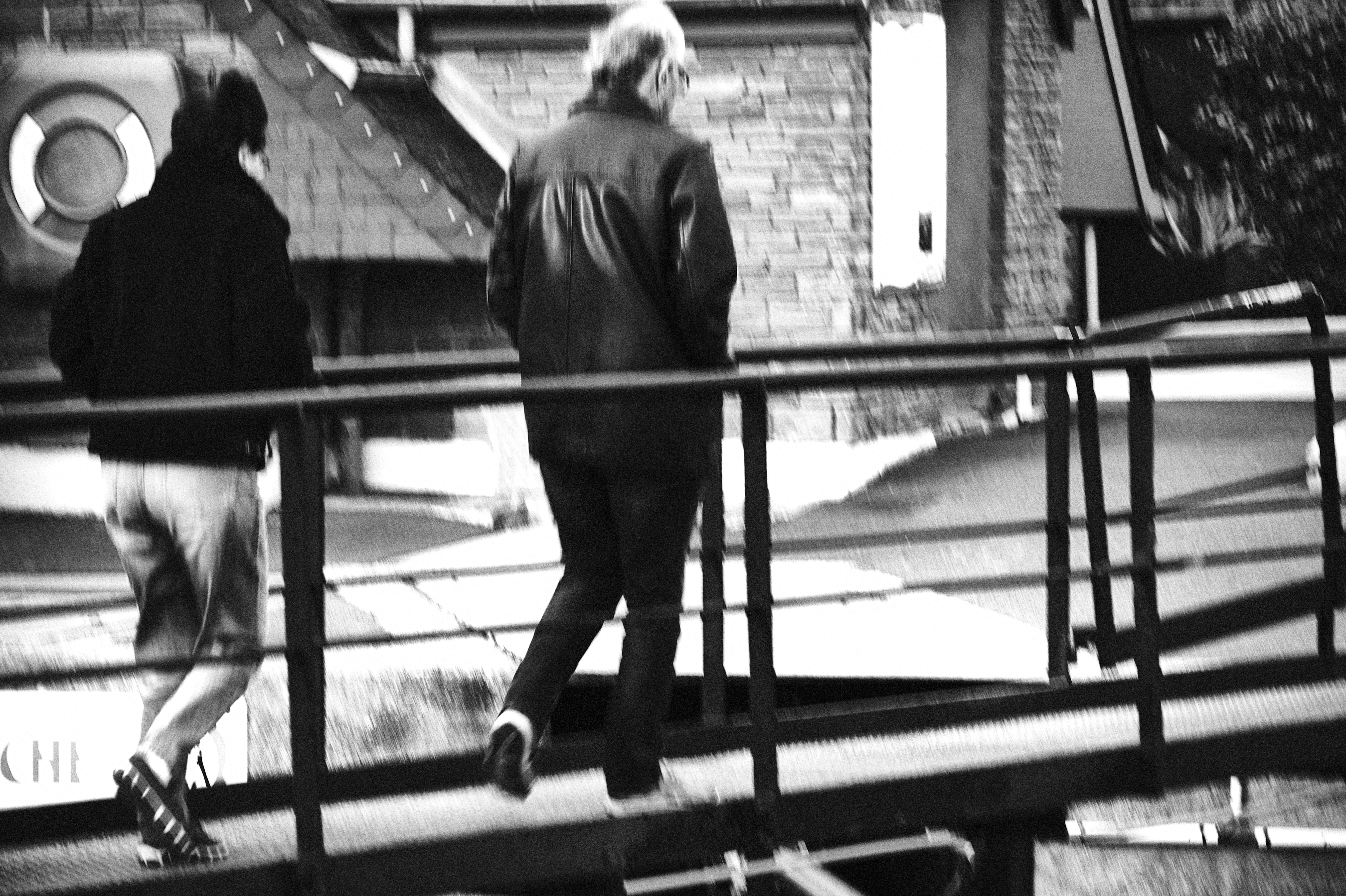 Two Walkers Across a City Railing