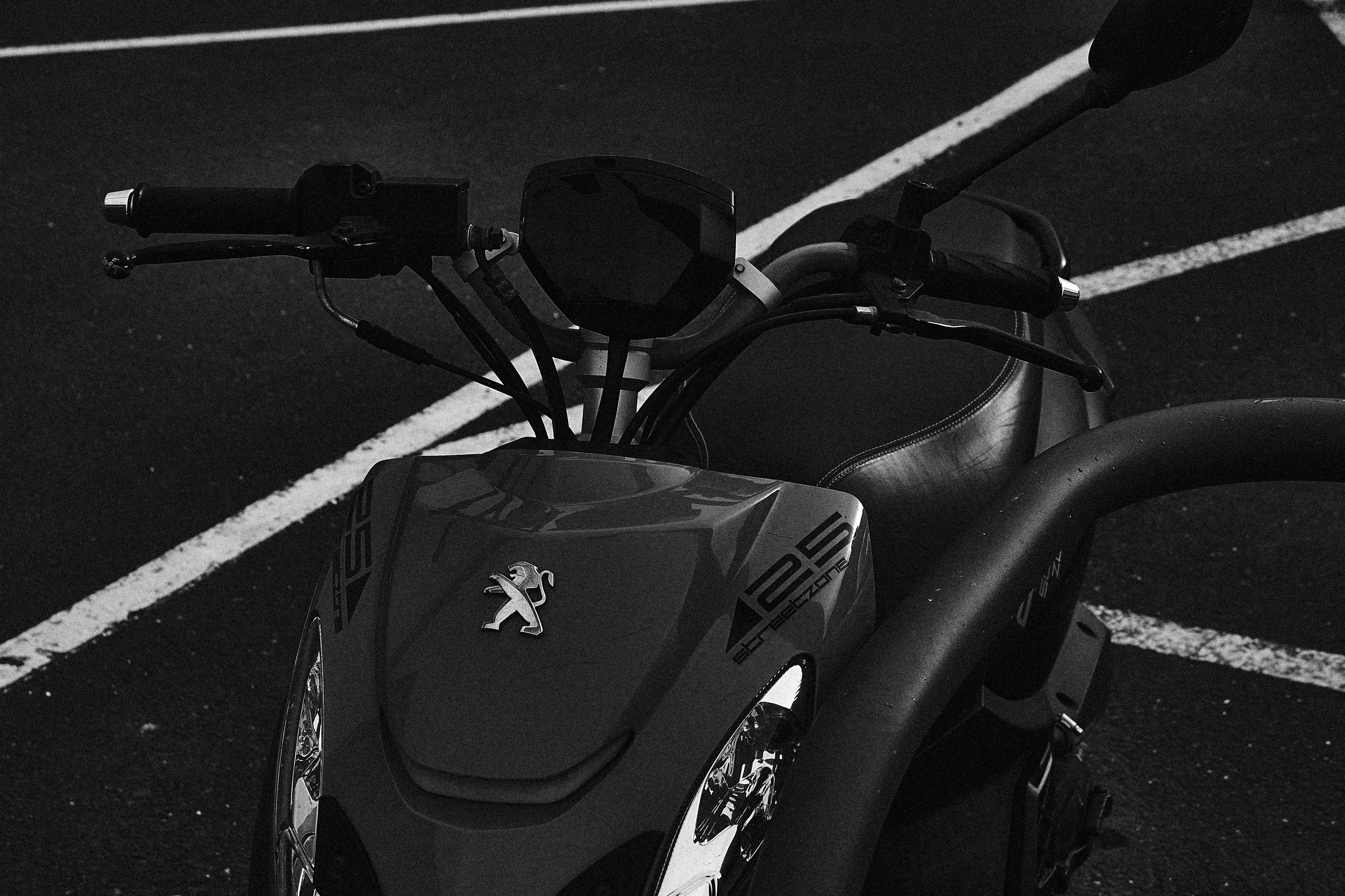 Midnight Ride: A Peugeot motorcycle under subdued parking-lot light