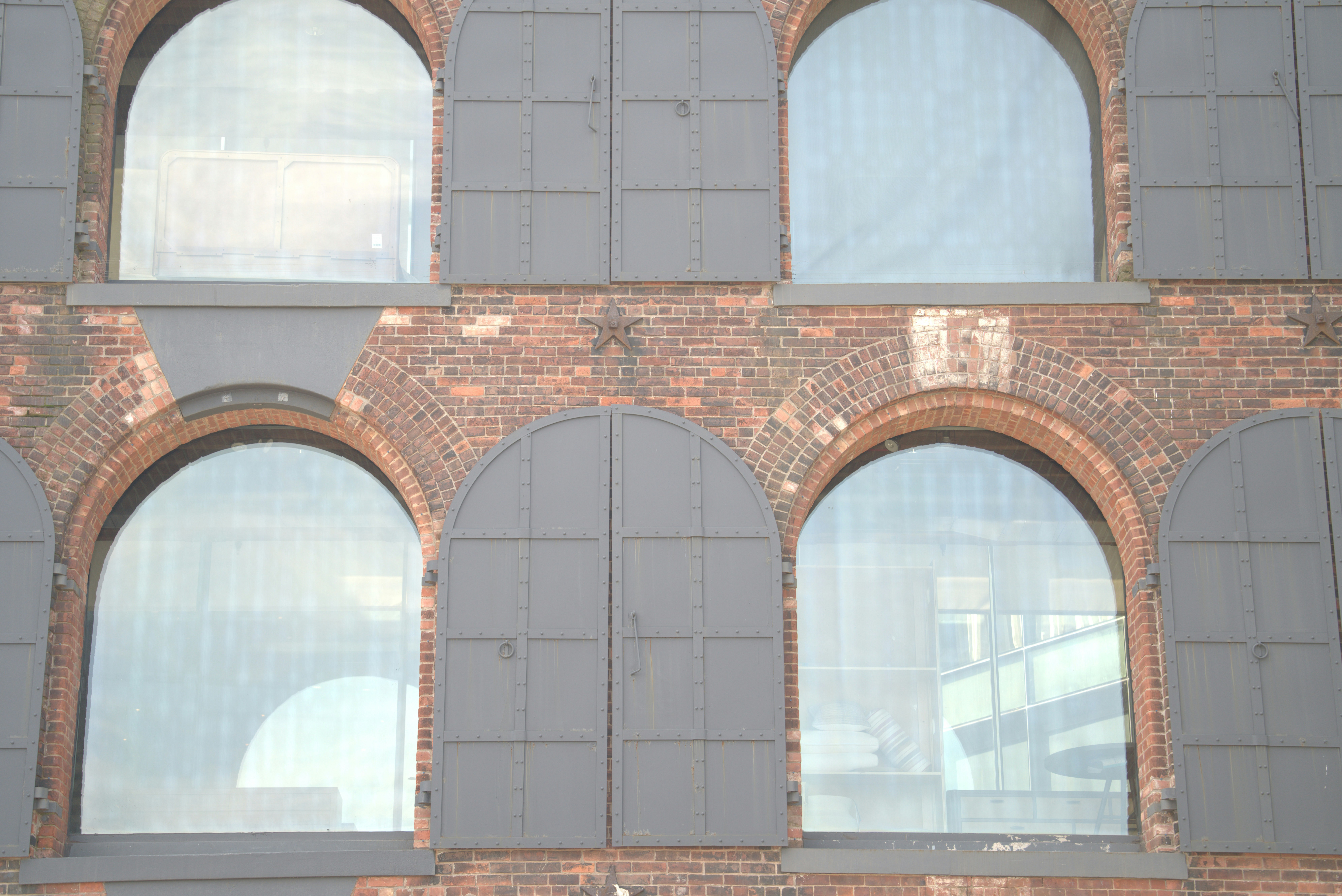 Arched Brickwork Echoes: Reclaimed Windows on a Quiet Facade