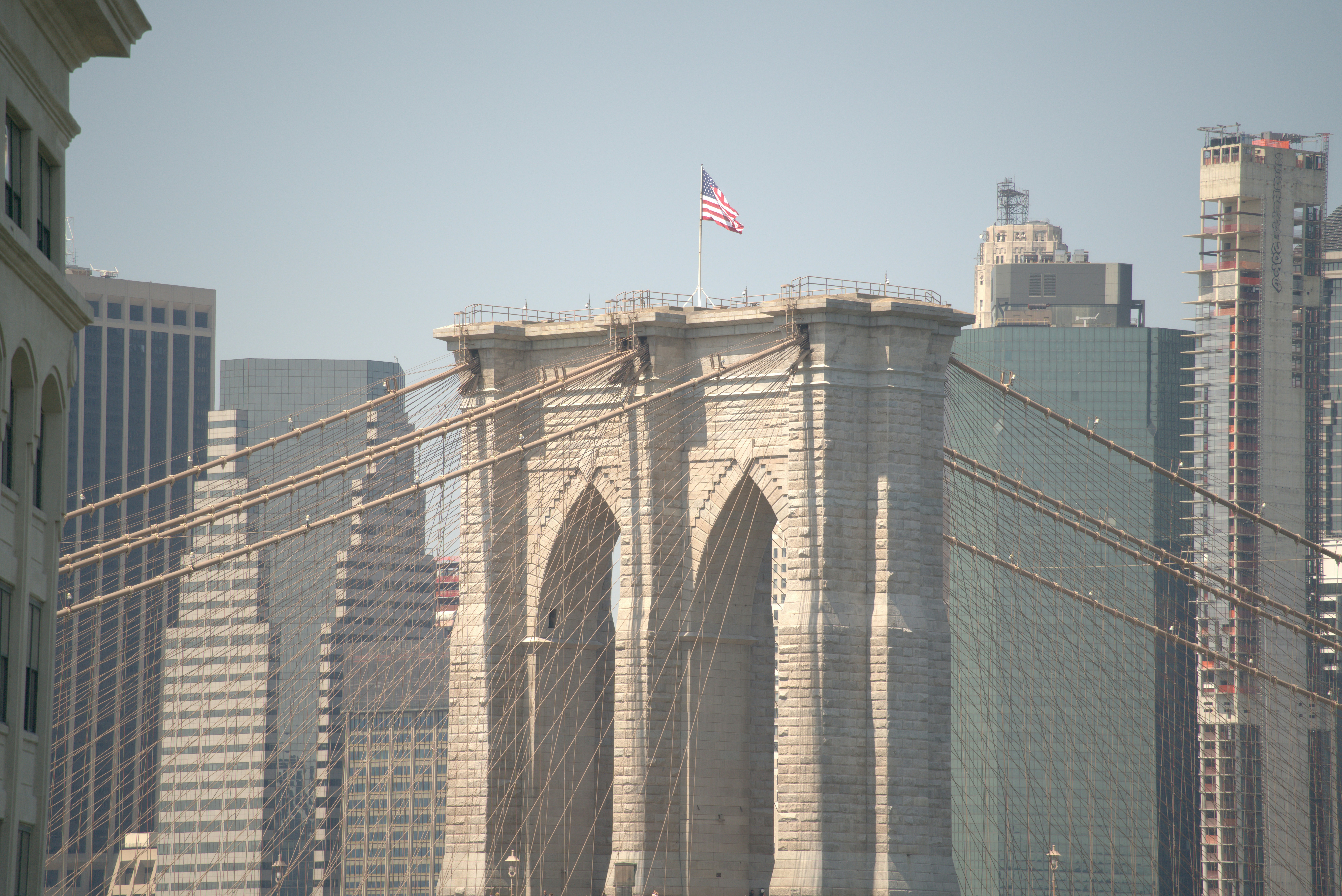 Suspended Giants: The Brooklyn Bridge Anchored by an American Flag
