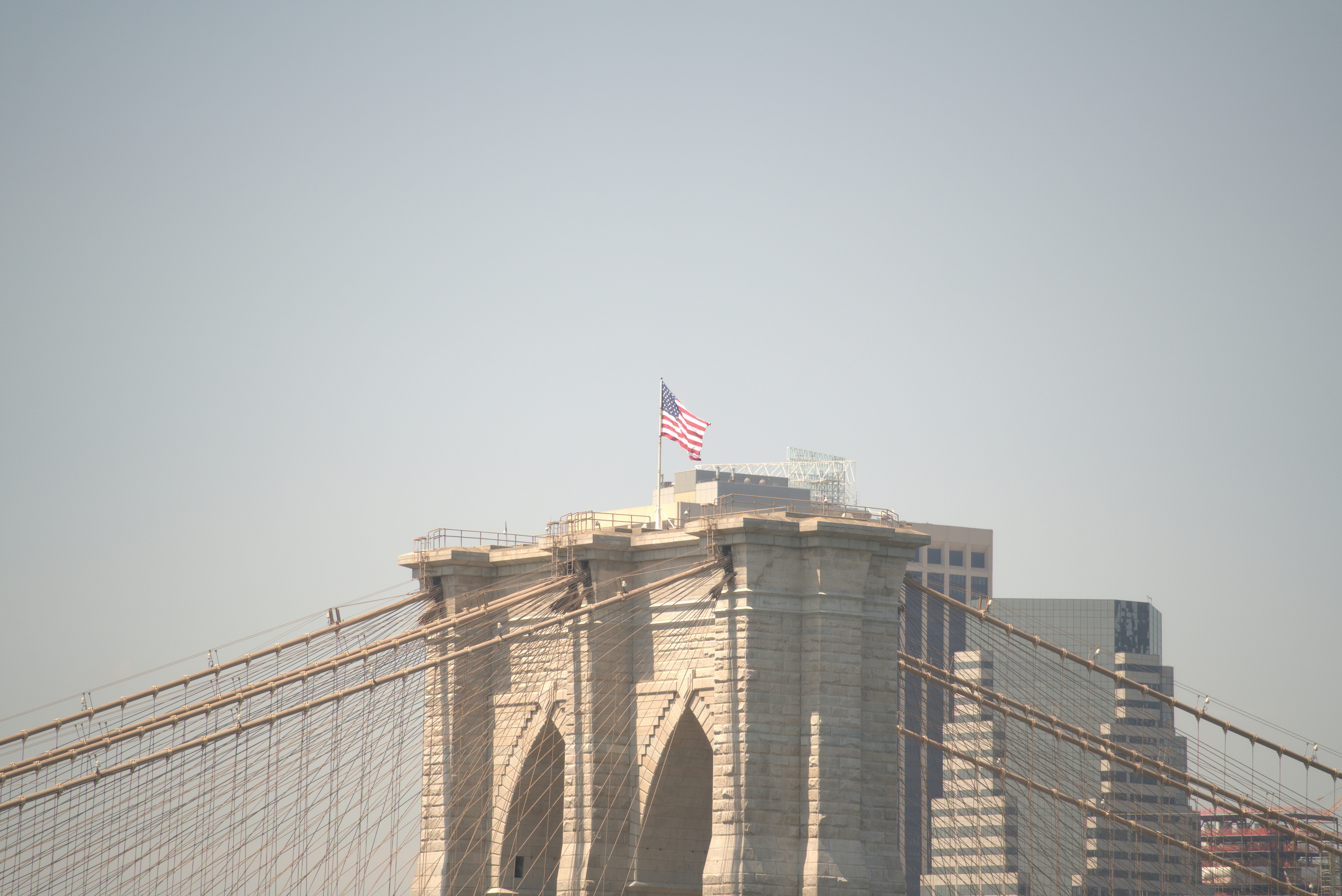 Flag atop the stone arches: a distant view of a bridge tower