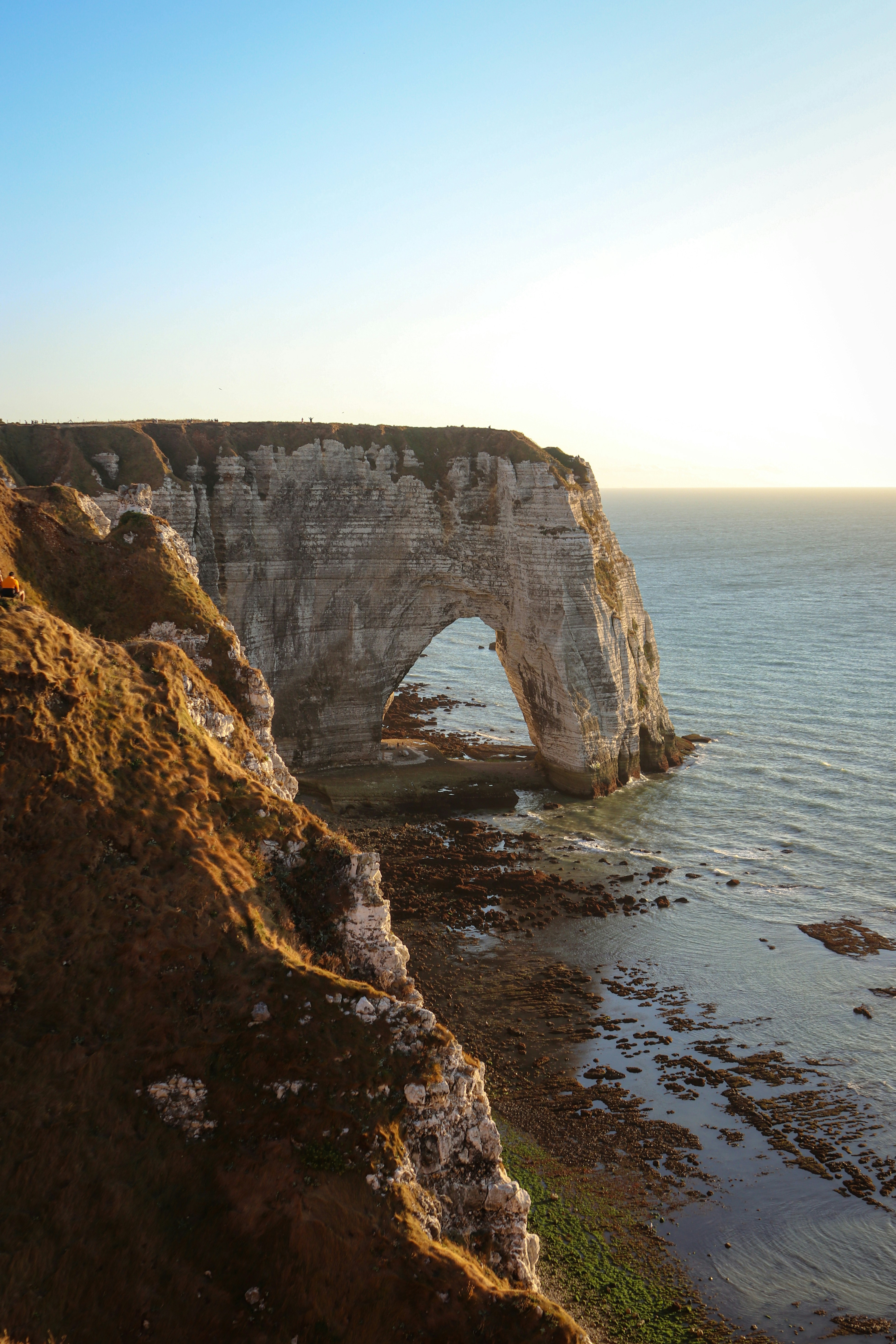 Sunlit Arch: Cliffside Gateway Over a Quiet Sea