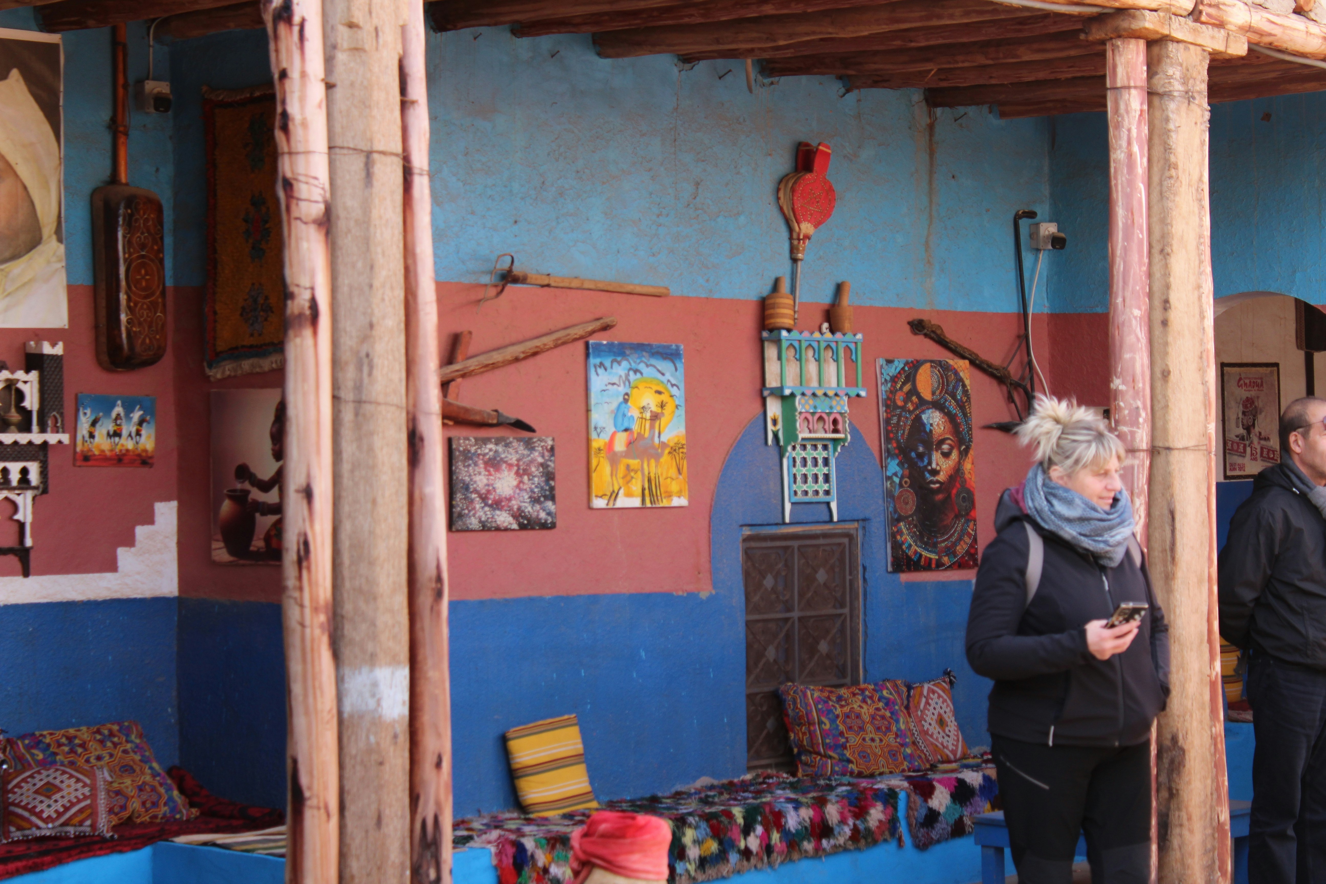 Colorful Wall Gallery: Portraits and Pillows in a Rustic Courtyard