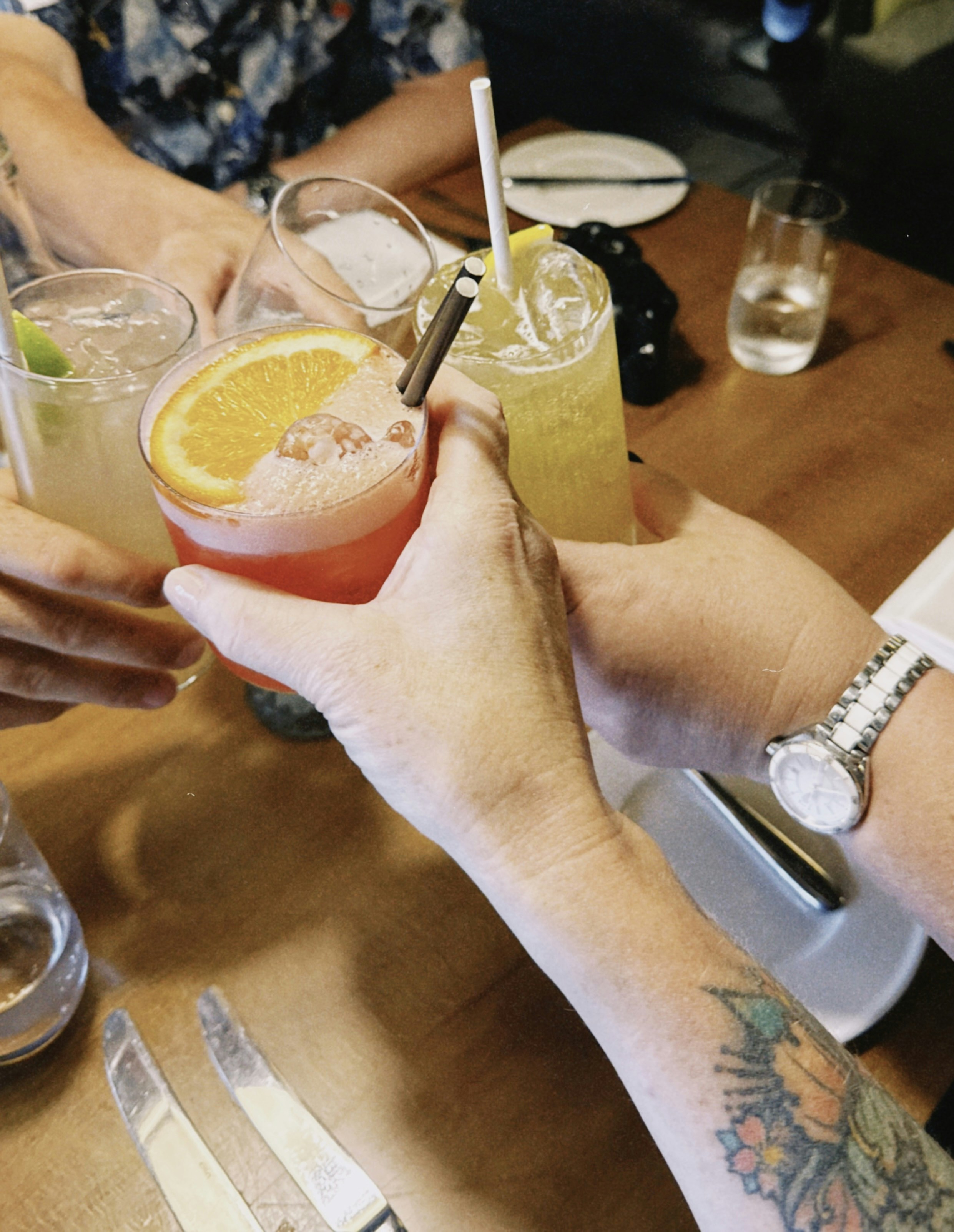 Toasts in Unison: A Shared Moment Around Citrus and Straw