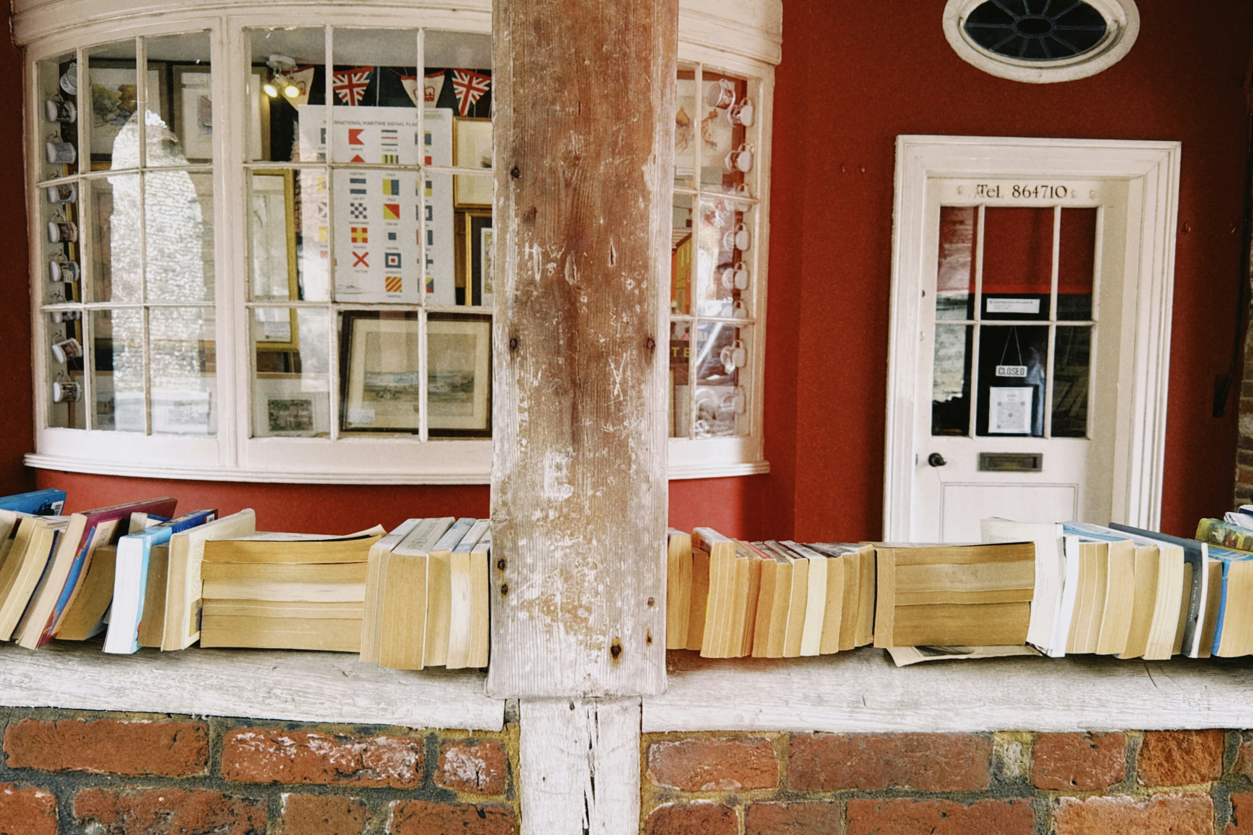 Books on a Bricked Porch: A Quiet Corner of a Red Front with a Painted Column