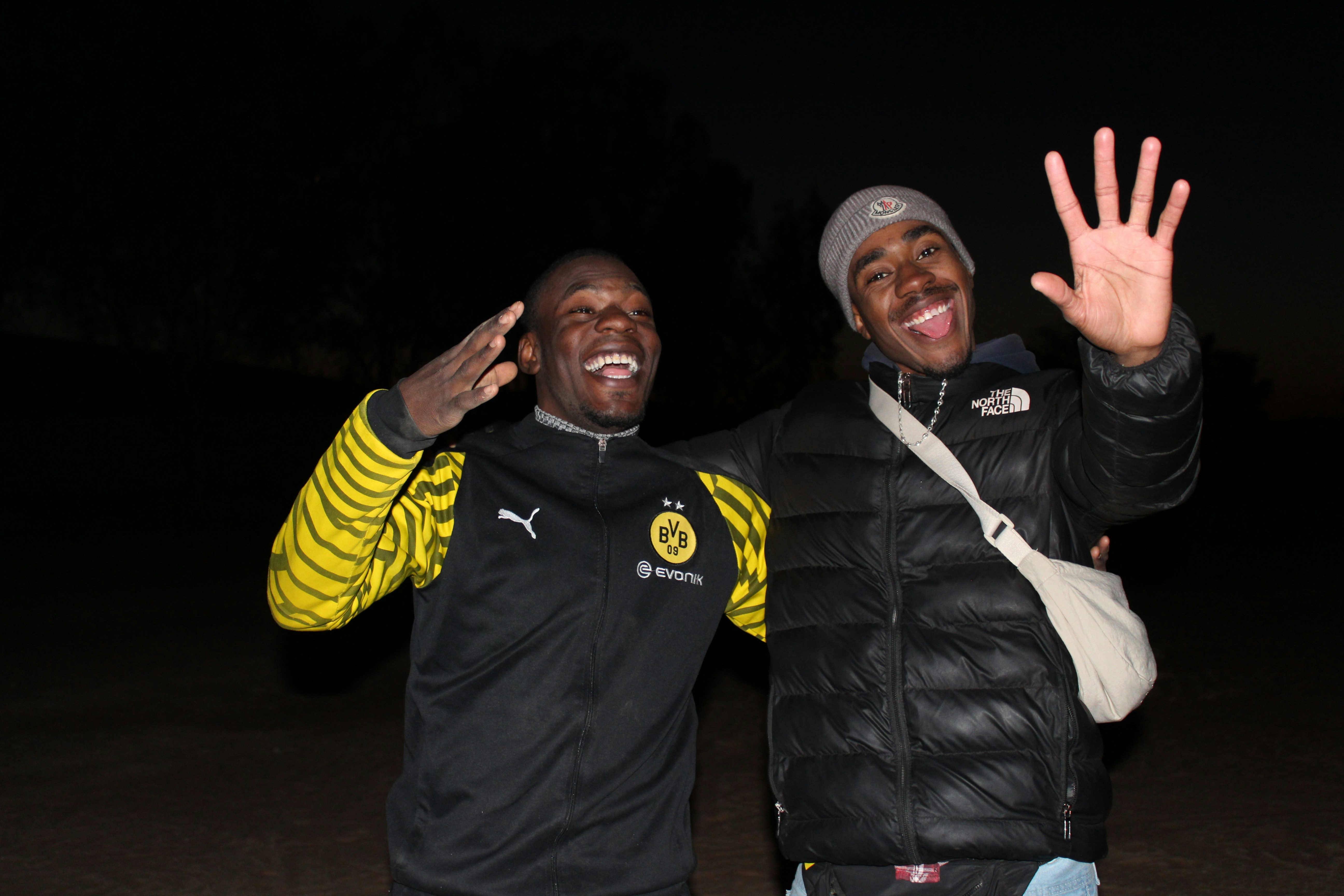 Joyful Night Out: Friends Wave Under Dark Sky