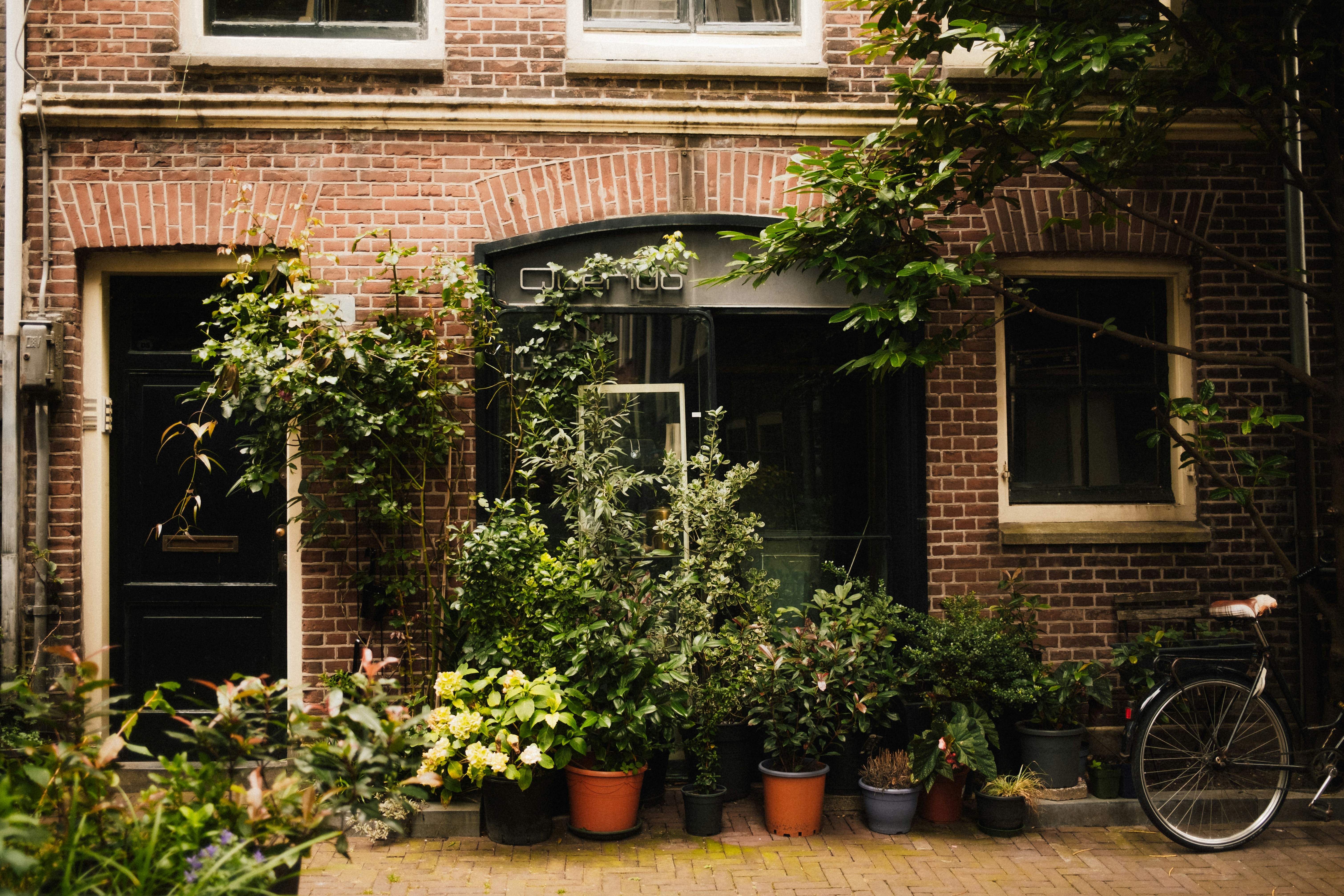 Brick frontage with lush entryway and bicycle