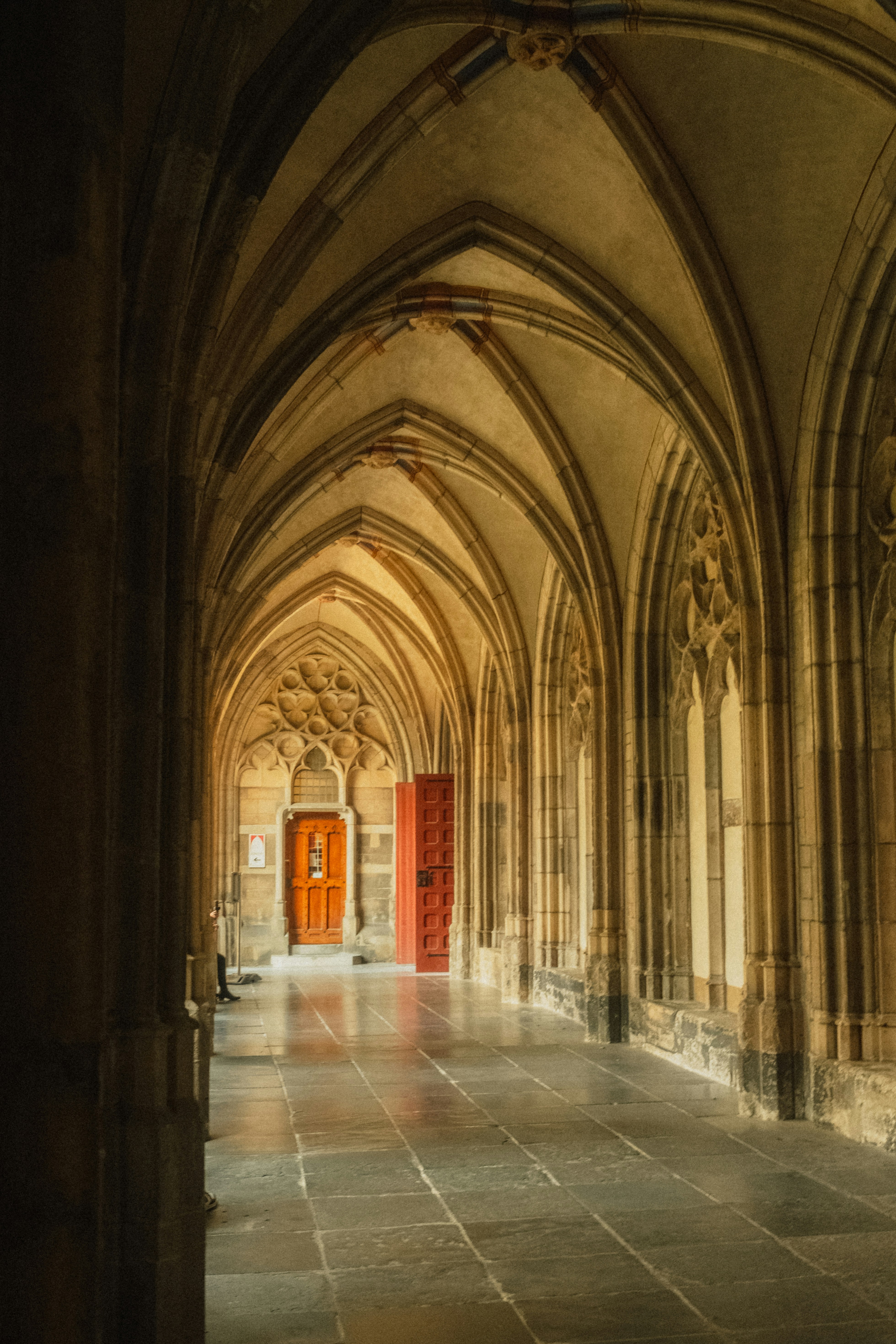 Red Door Corridor: Gothic Vaults Framing a Quiet Path