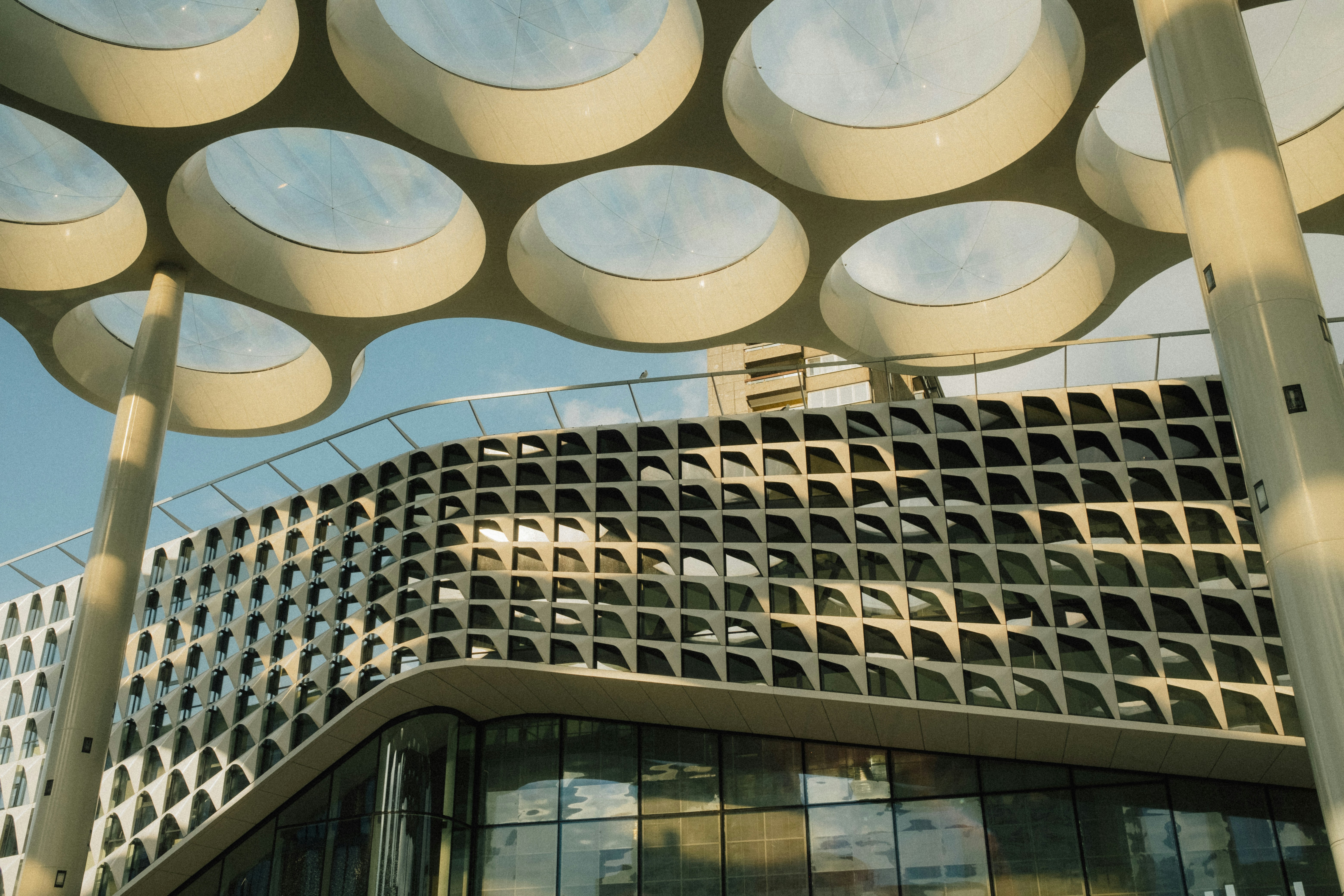 Hexagonal Facade Echoes: Modern Canopy Over a Glassy Atrium