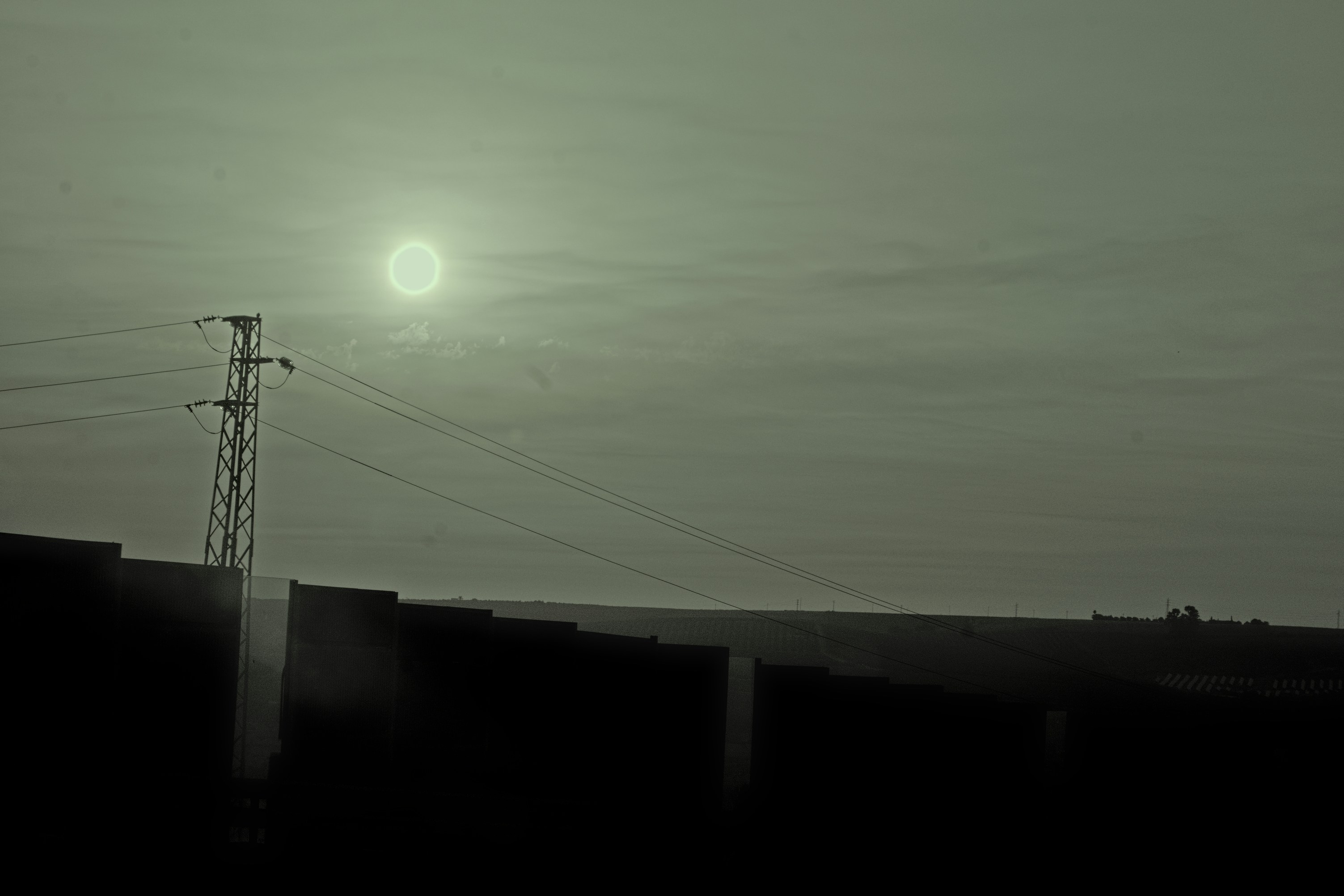 Sun Halo over Industrial Silhouette at Dusk