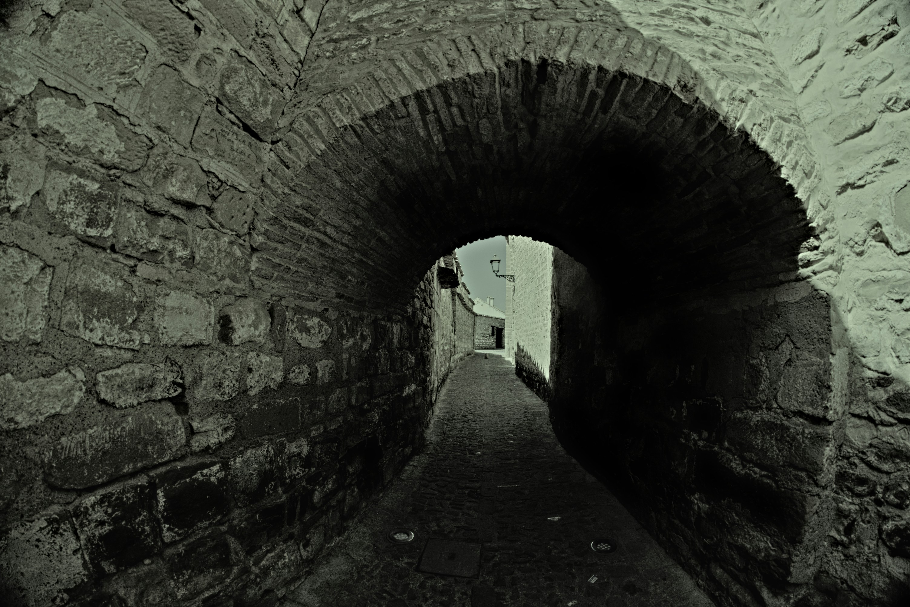 Light at the End of the Arch: A Narrow Street Through Stone Archway