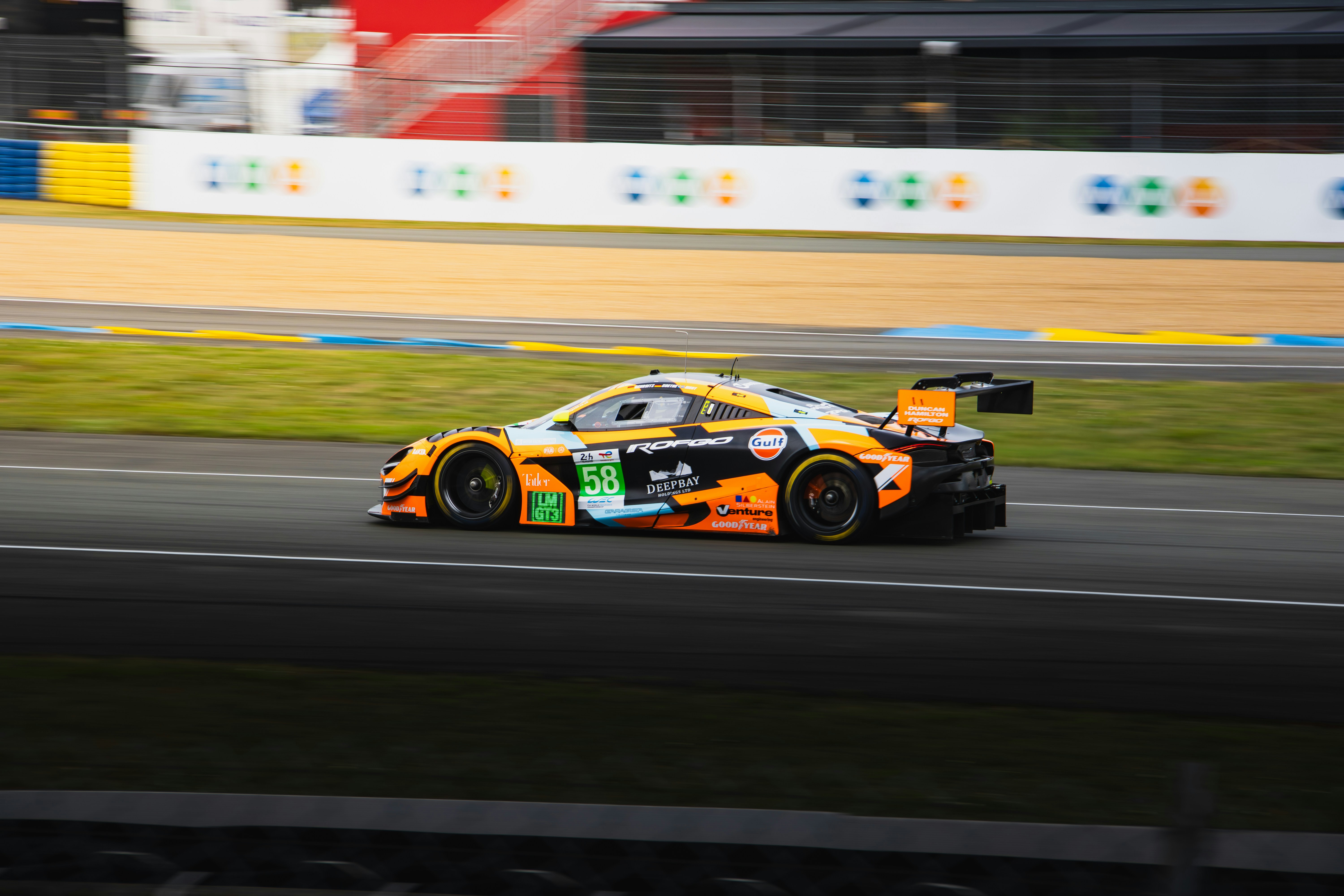 Blitz on the Track: Orange Racer in a Fast Forward Blur