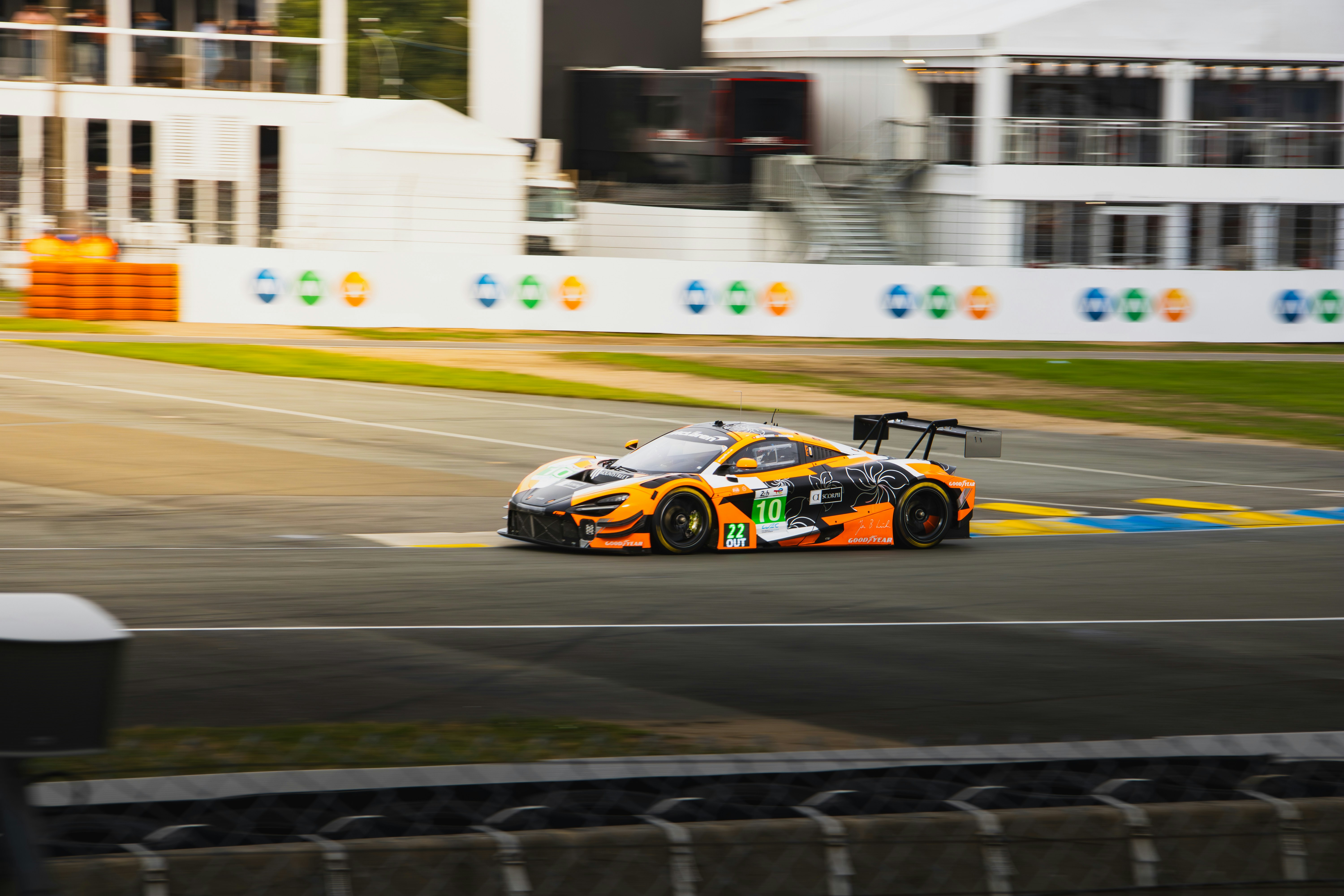 Blazing Lap: Orange race car carving through a track bend