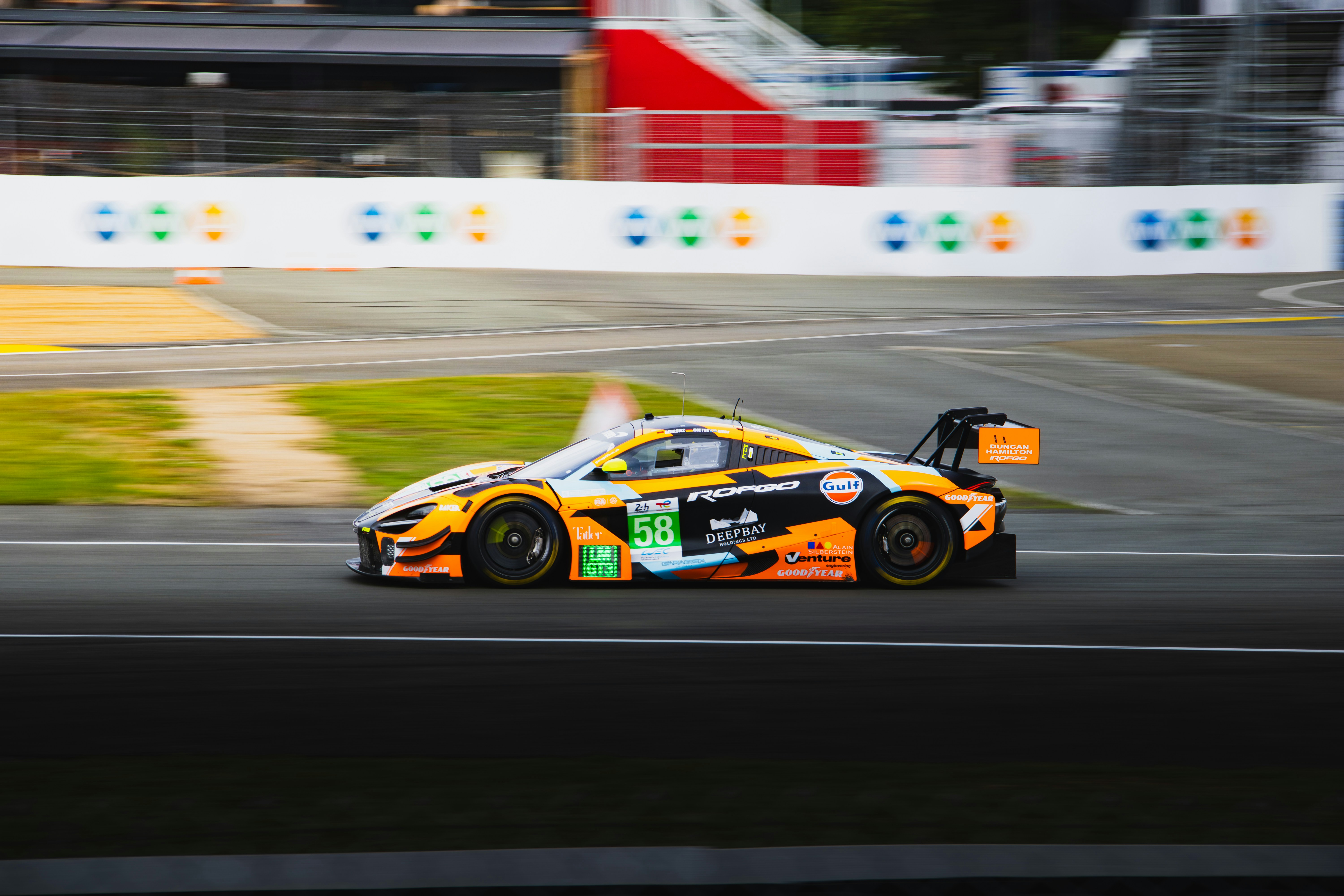  Blaze on Asphalt: Orange Racer Speeds by in a Blur of Color