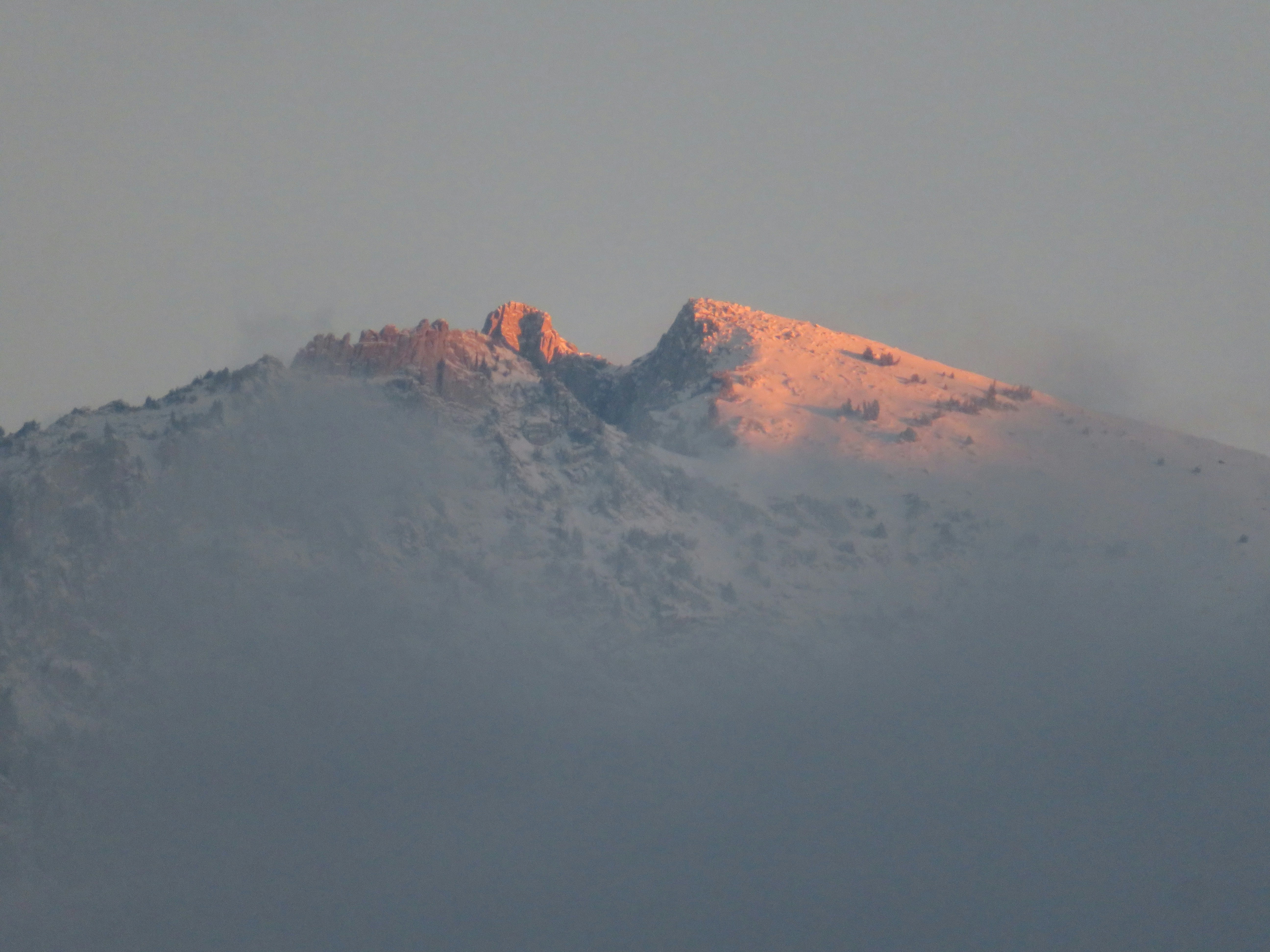 Sunlit Apex: A Mountain Crest Pierced by First Light