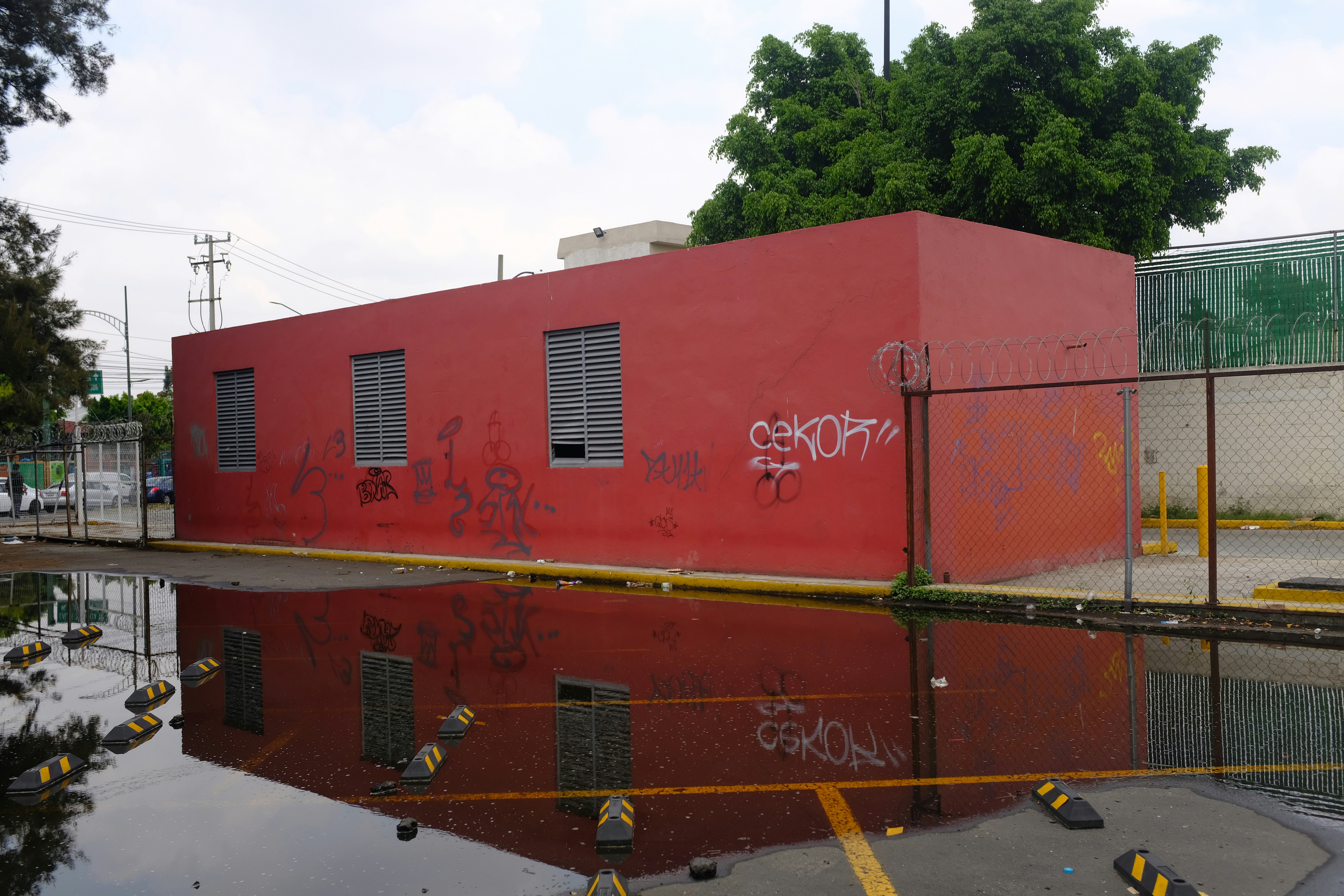 Red Blocked Facade Amid Street Reflections