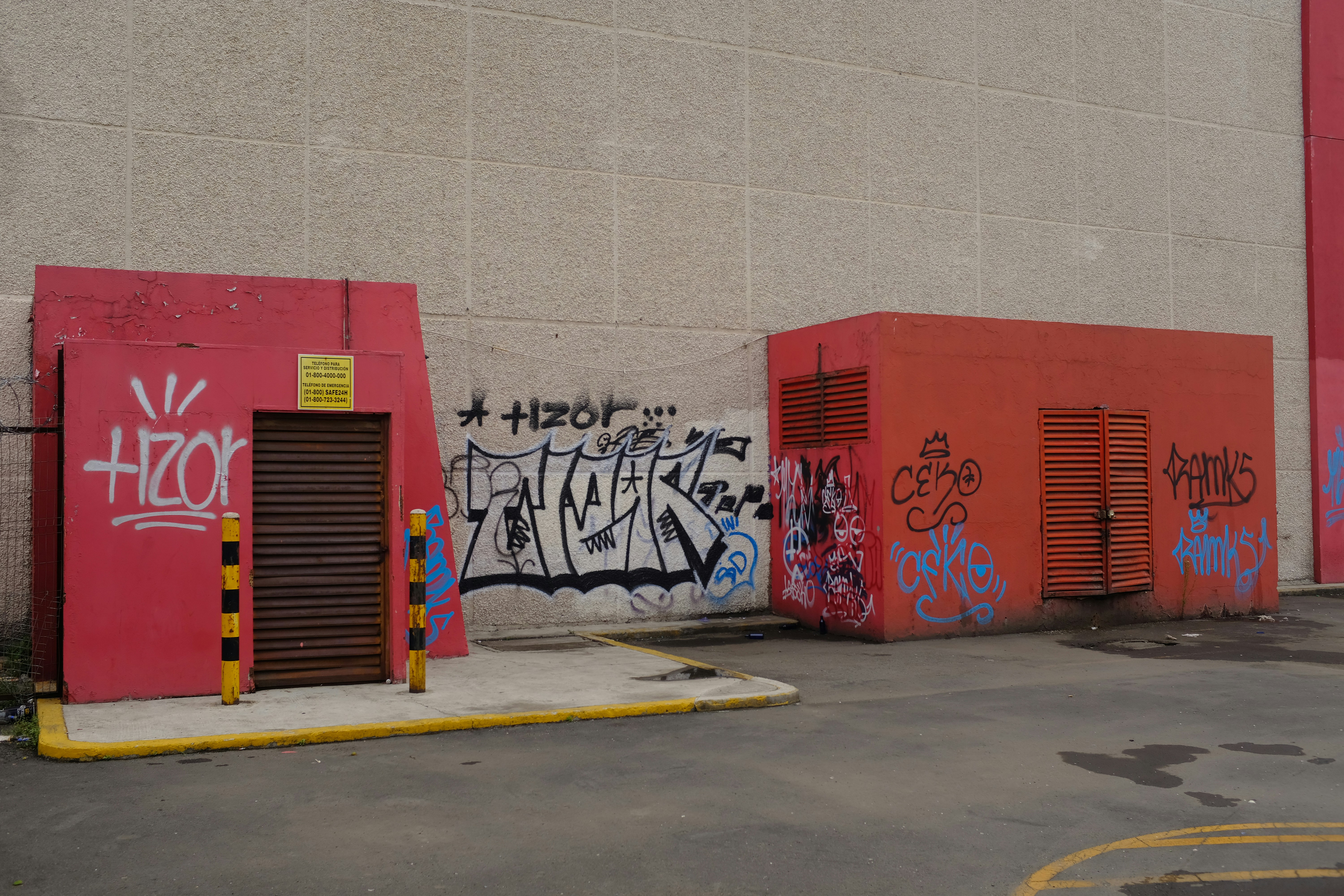 Red Utility Boxes and Graffiti at a Guarded Corner