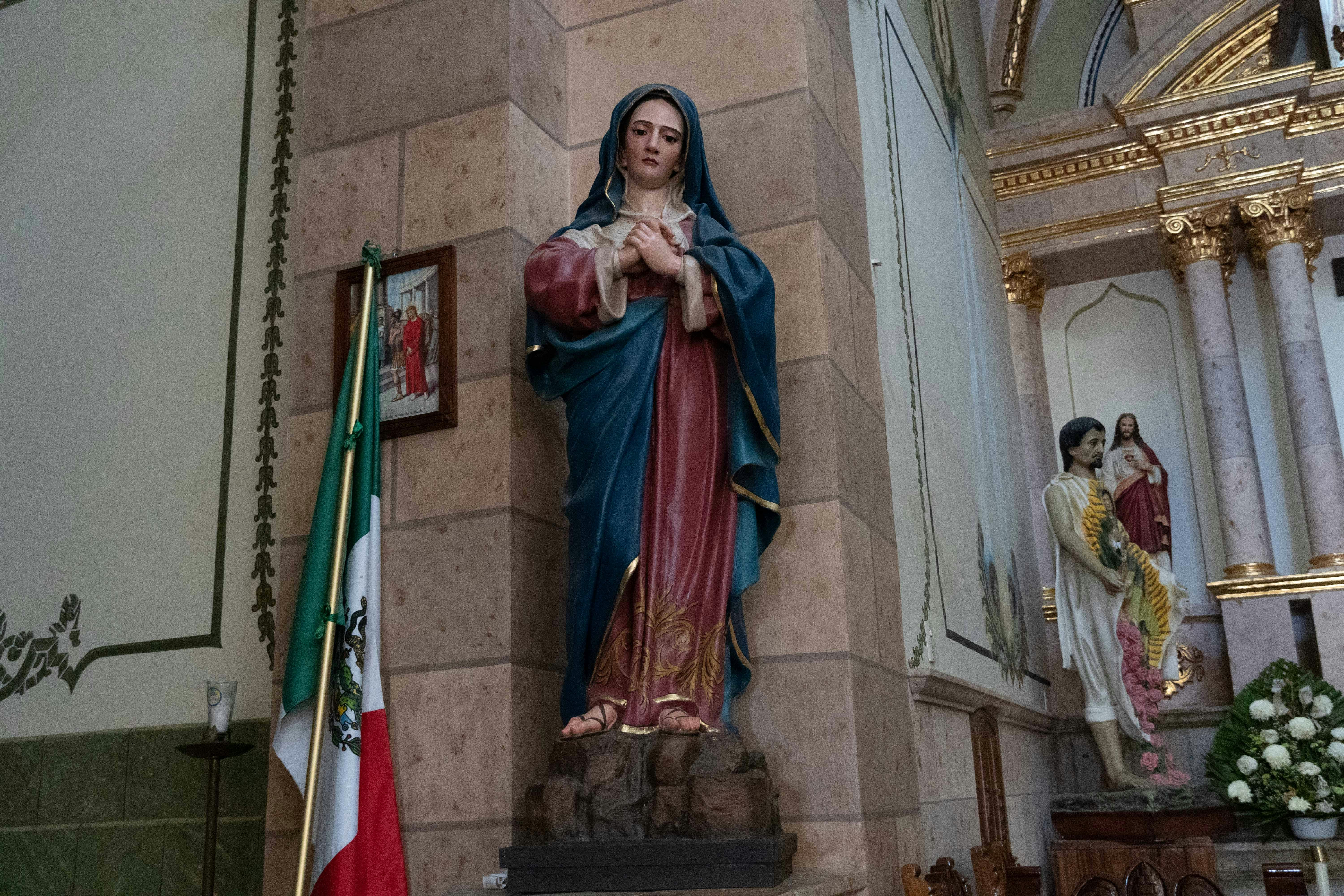 Virgin Statue by the Altar, Guarded by Flags and Gold-Accented Architecture