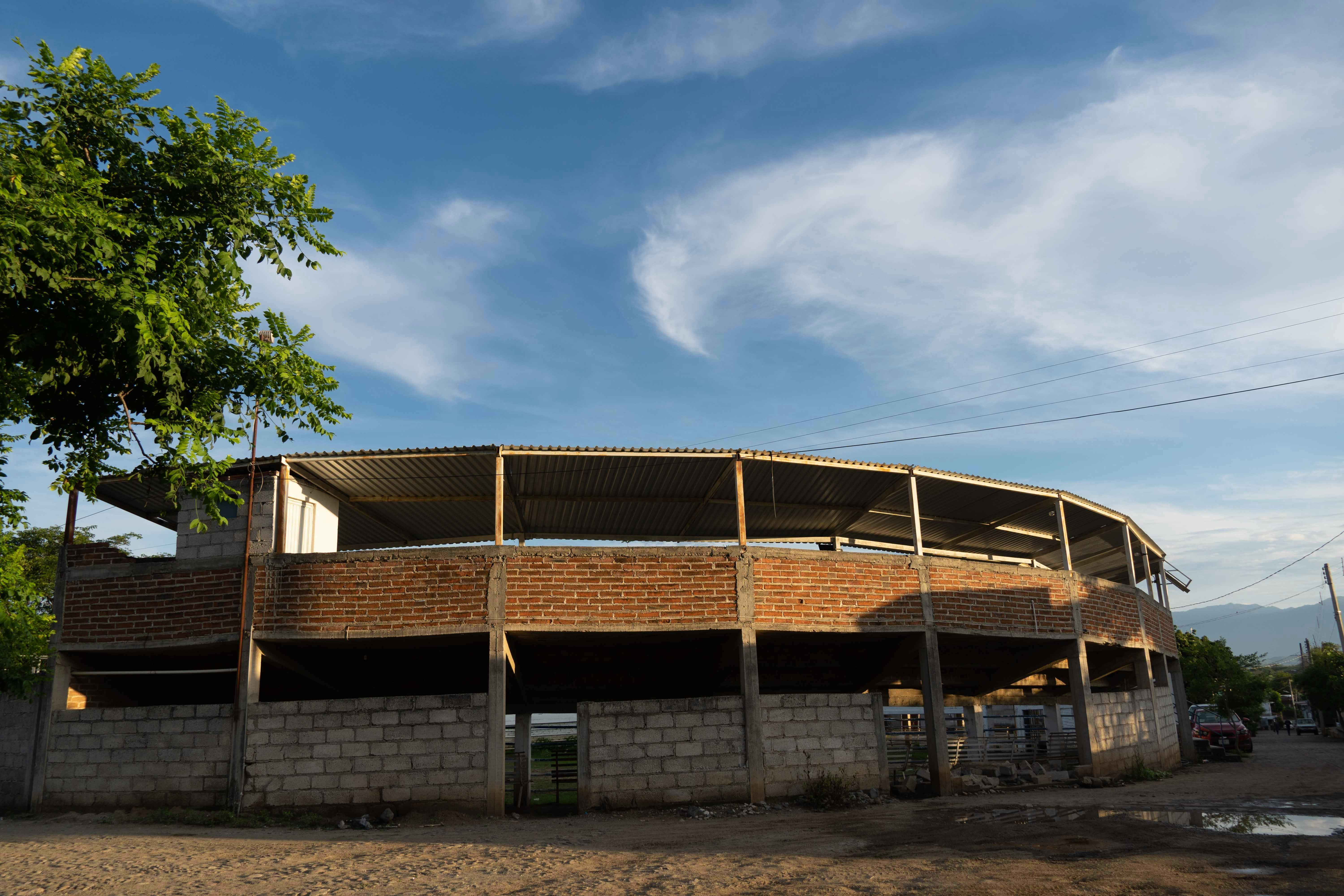 Open-Structure at Dusk: Brick-and-Circa Frame under a Blue Sky