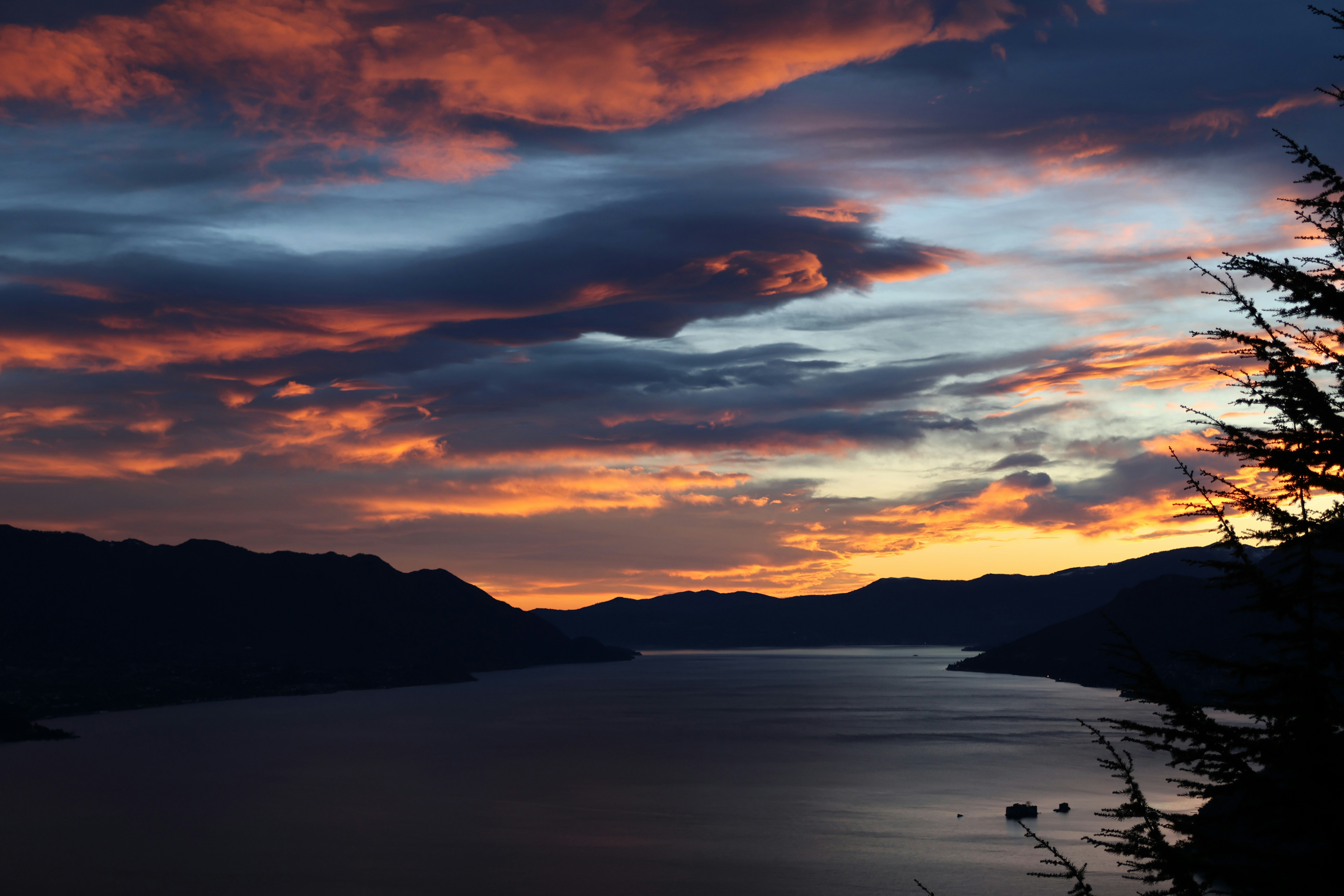Silhouetted Gorge at Dusk: Coral Clouds Over a Quiet Lake